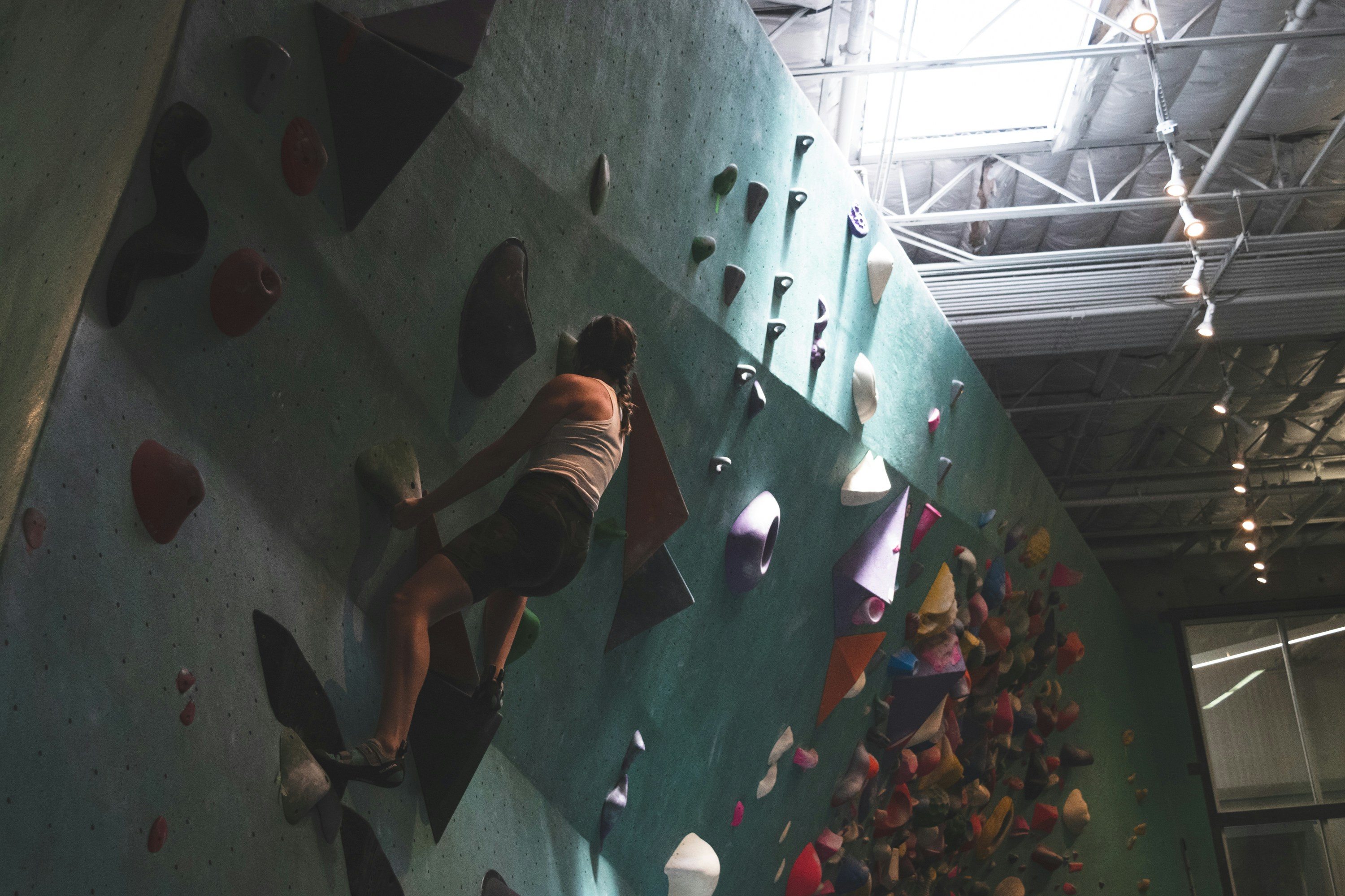 A man climbing up the side of a climbing wall photo – Free Shadow Image ...