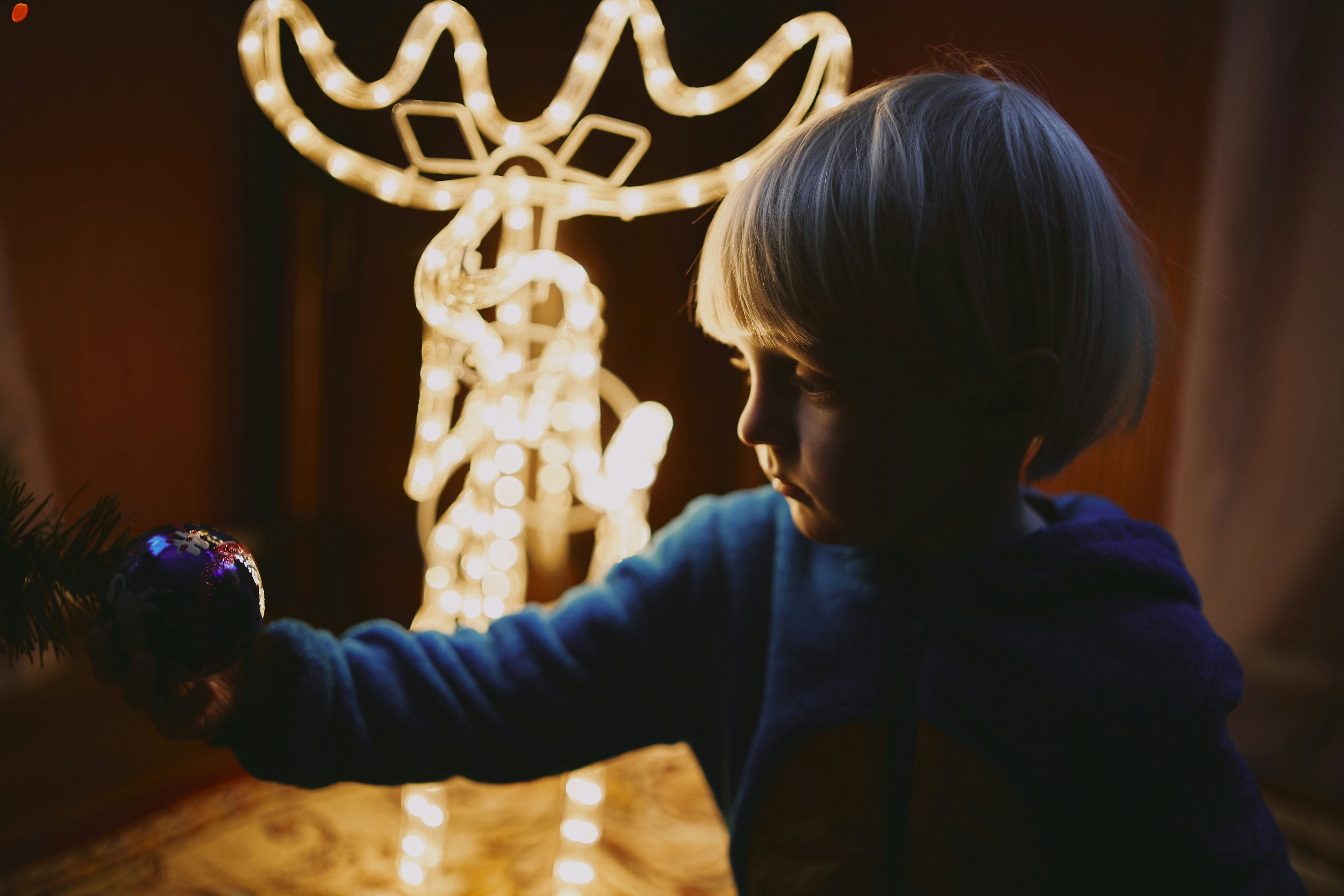 Touching the Glow: A Child Reaches for the Neon Reindeer