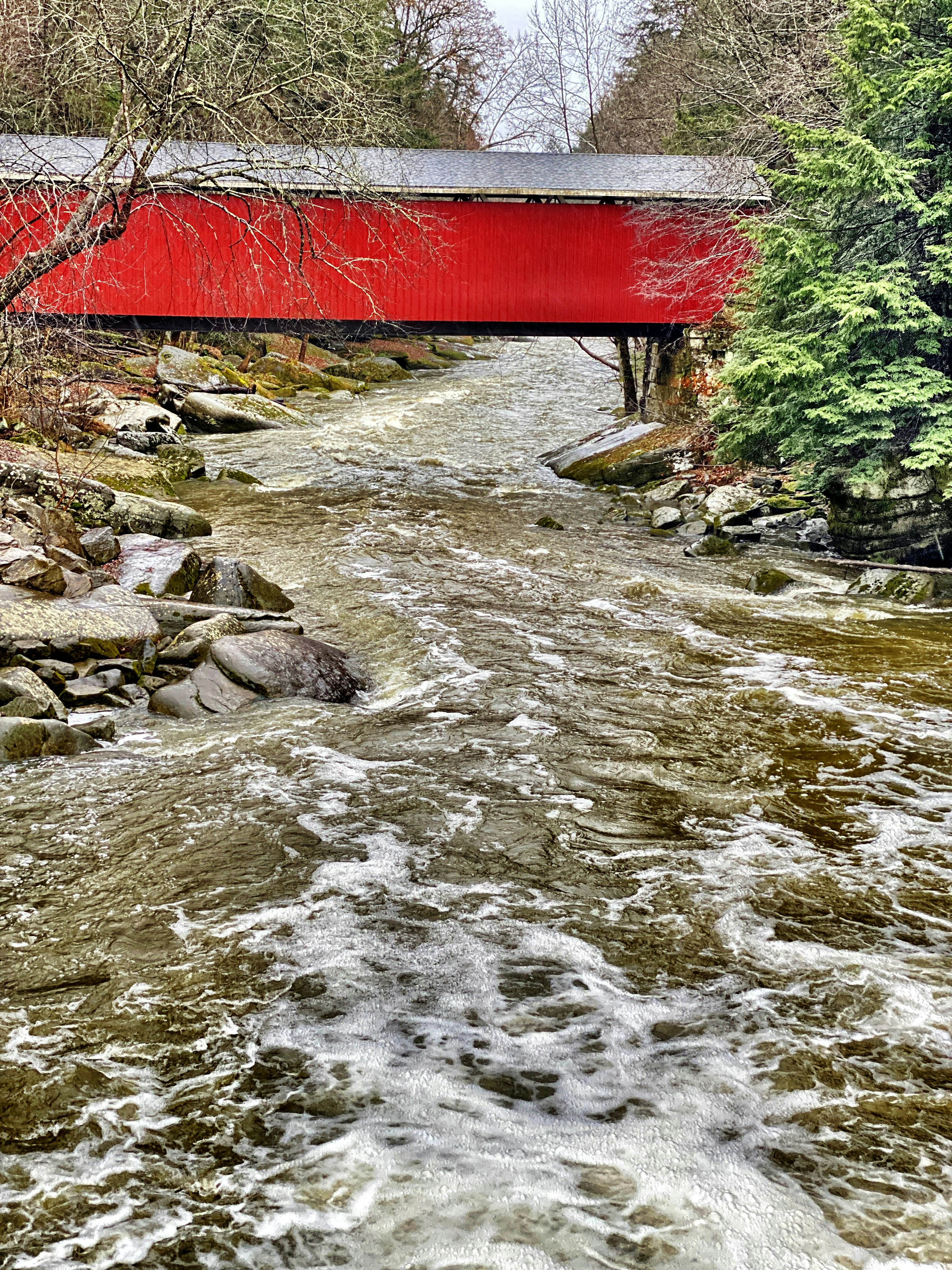 The churning white water of the Slippery Rock Creek as it flows under the McConnells Mill Covered Bridge in Lawrence County, Pennsylvania.