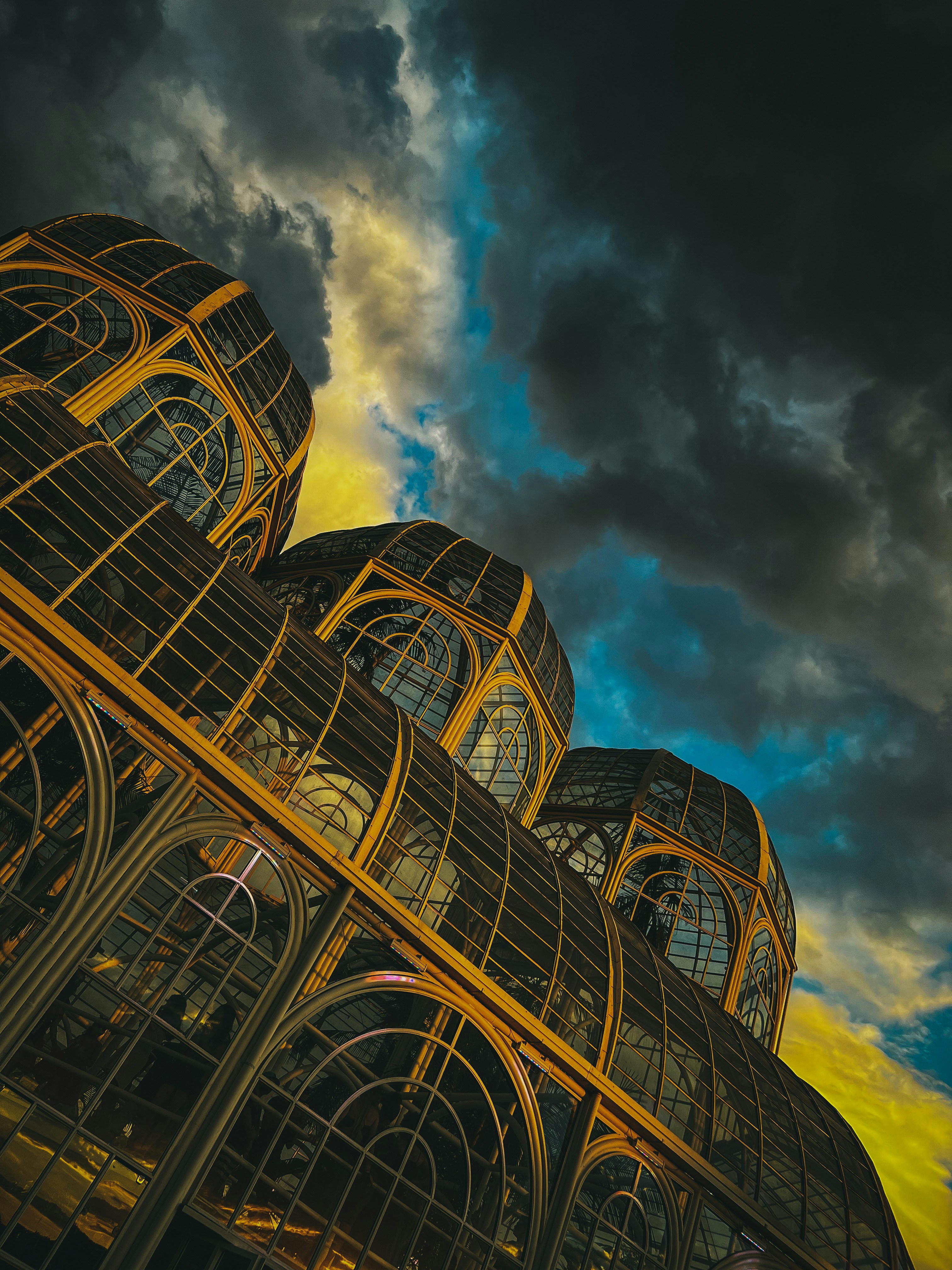 Curved Glass Cathedral under a Turbulent Sky
