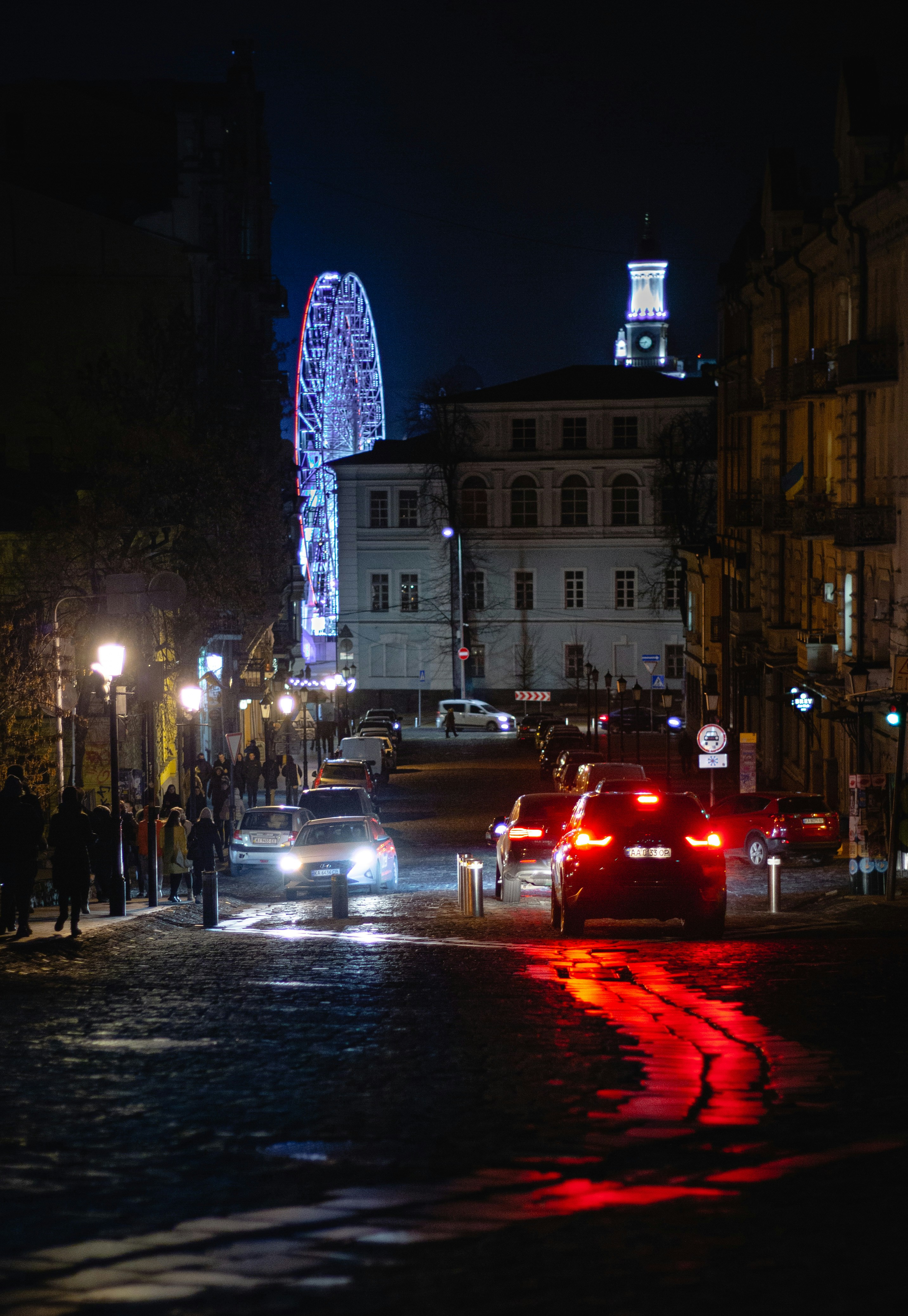 Blue Neon Ferris Wheel Over a Cobblestone Night Street