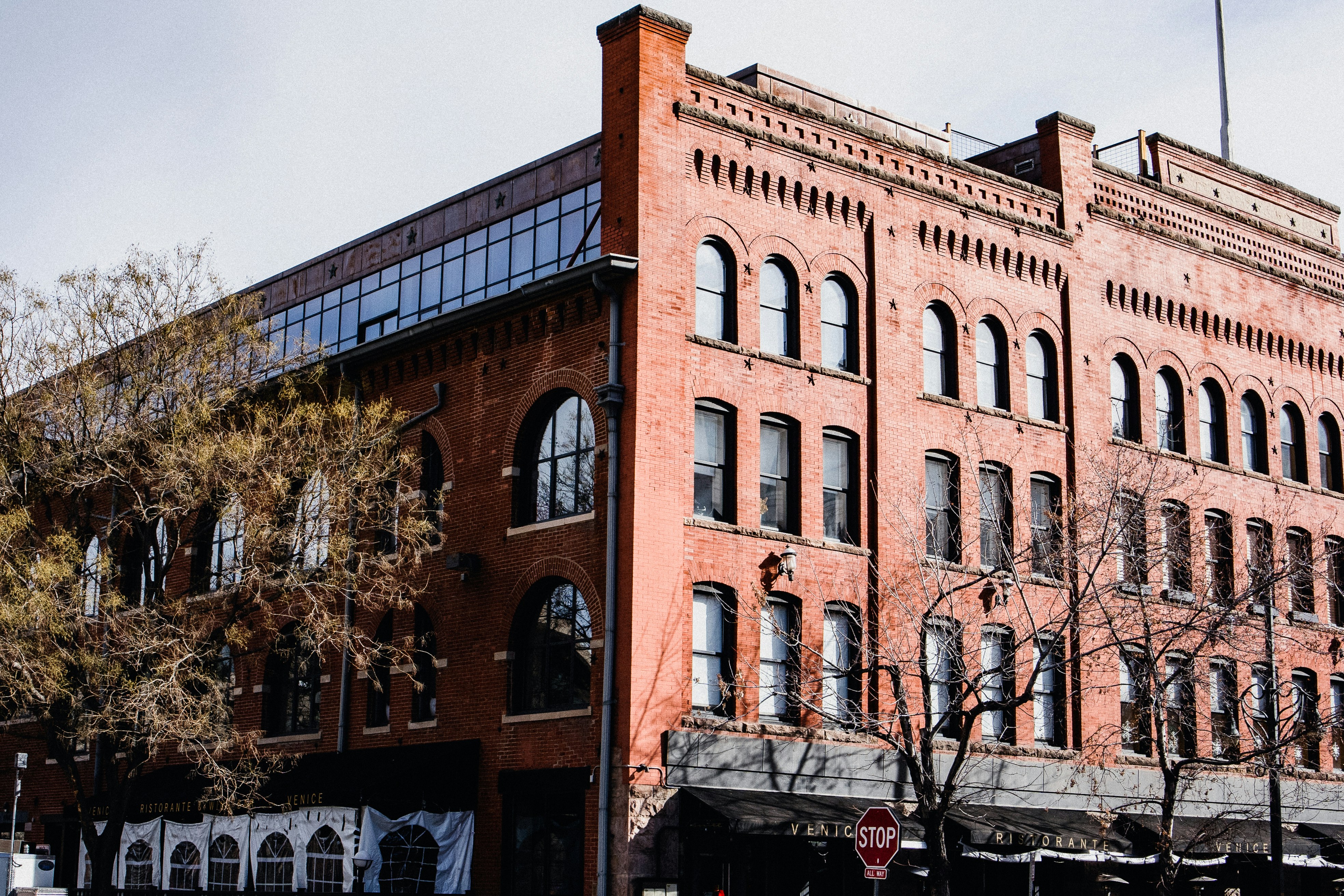 An old brick building with a street sign in front of it photo – Free ...