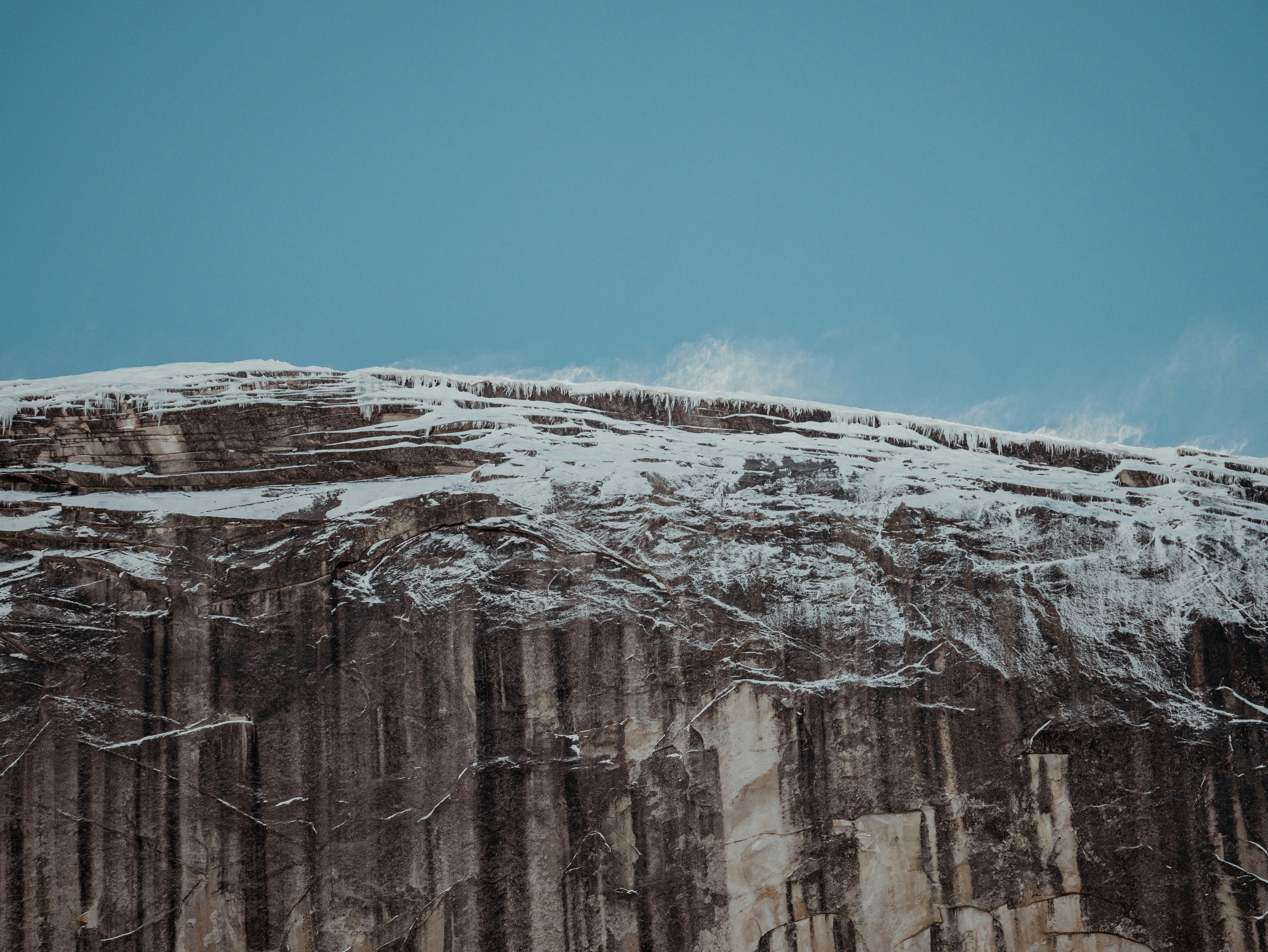 Snow-etched cliffs under a crisp blue sky
