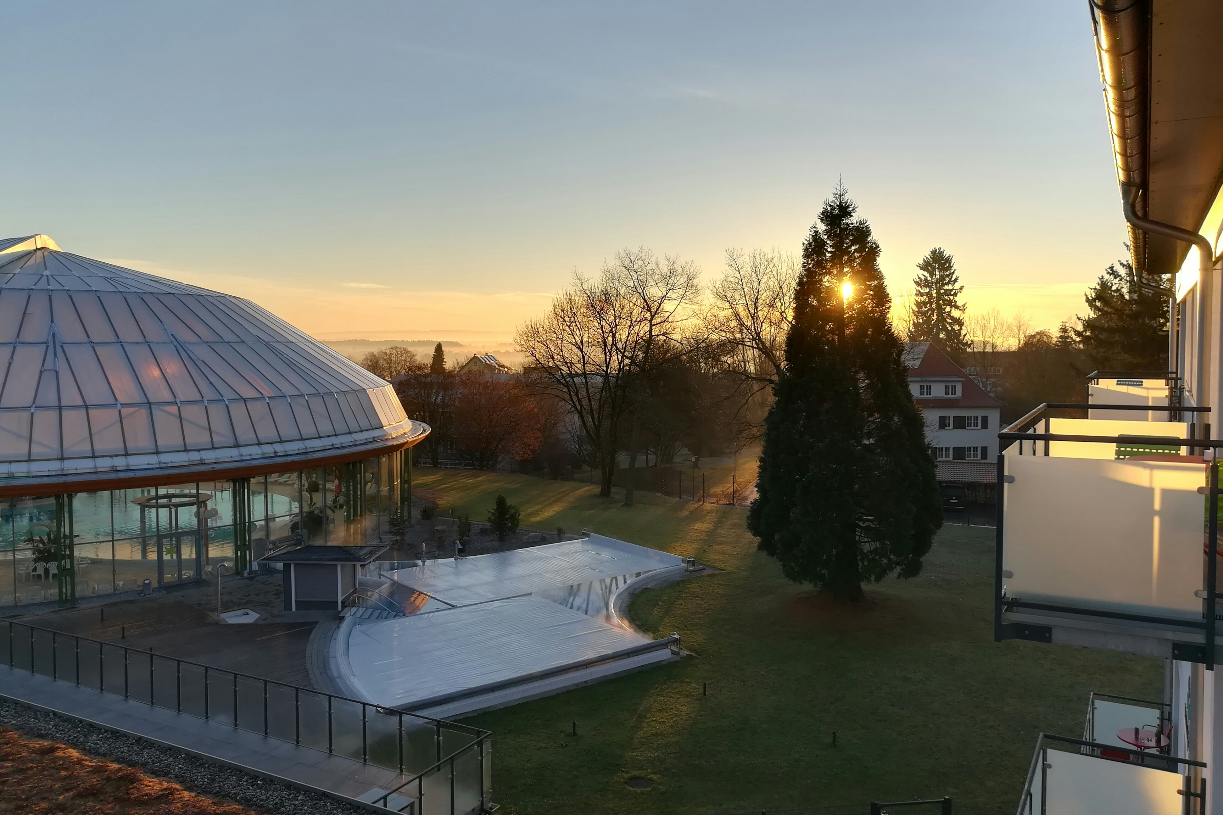 Dawn Light Over a Glass Dome and Tree-Lined Campus