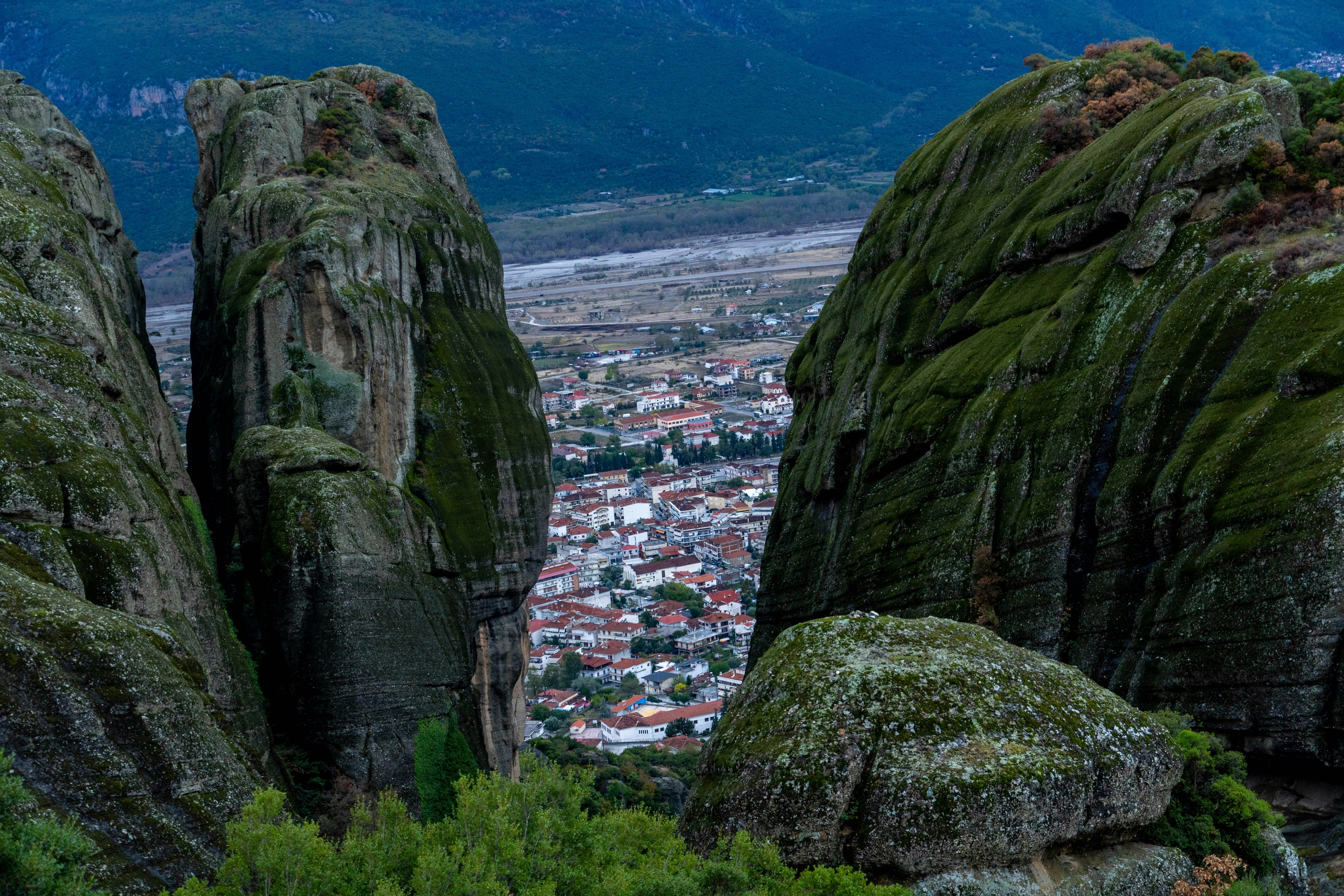 A city nestled between two large rocks in the mountains photo – Free ...