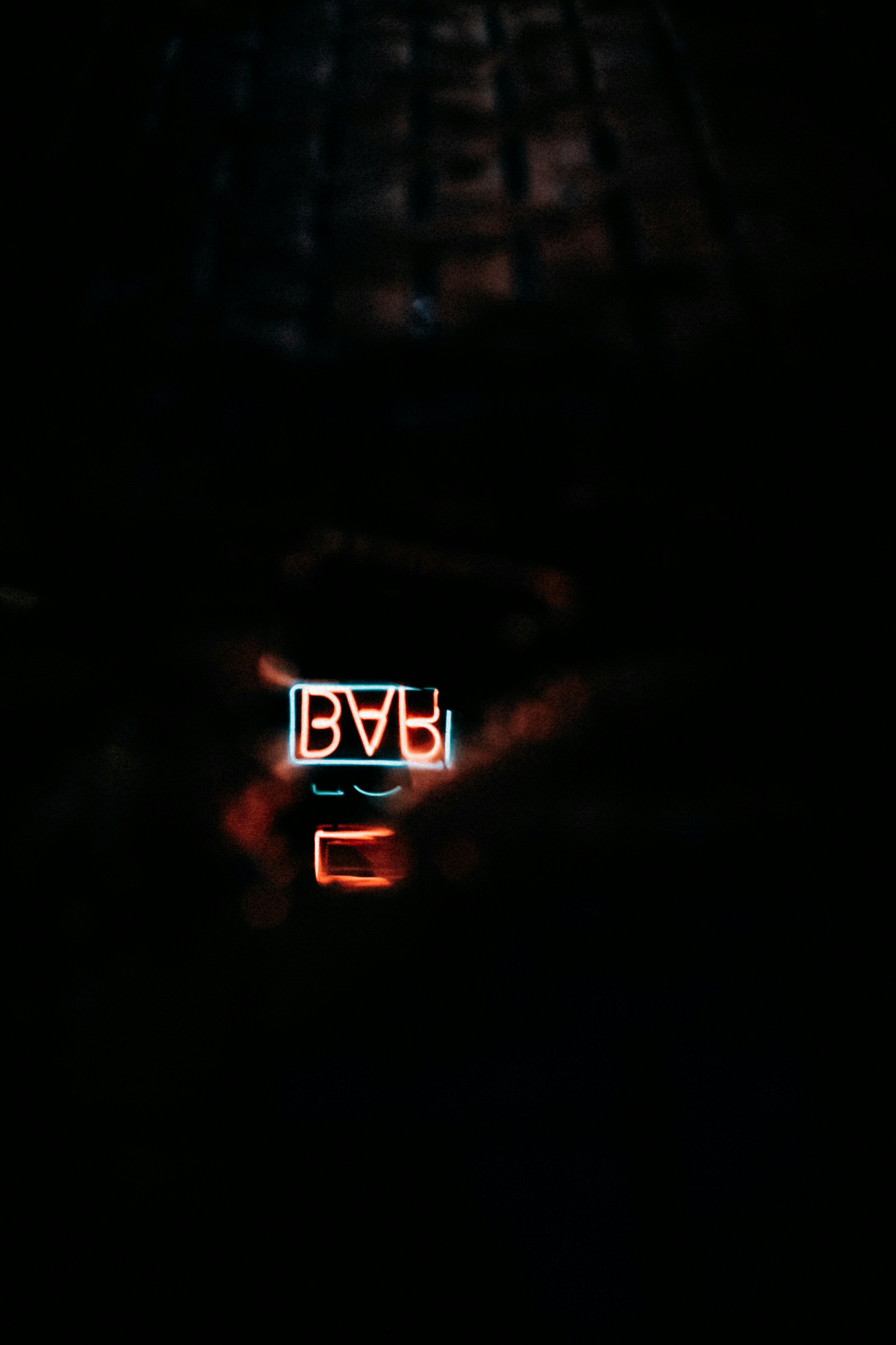 Neon Echo in Velvet Darkness: A Red Sign and Its Glassy Reflection