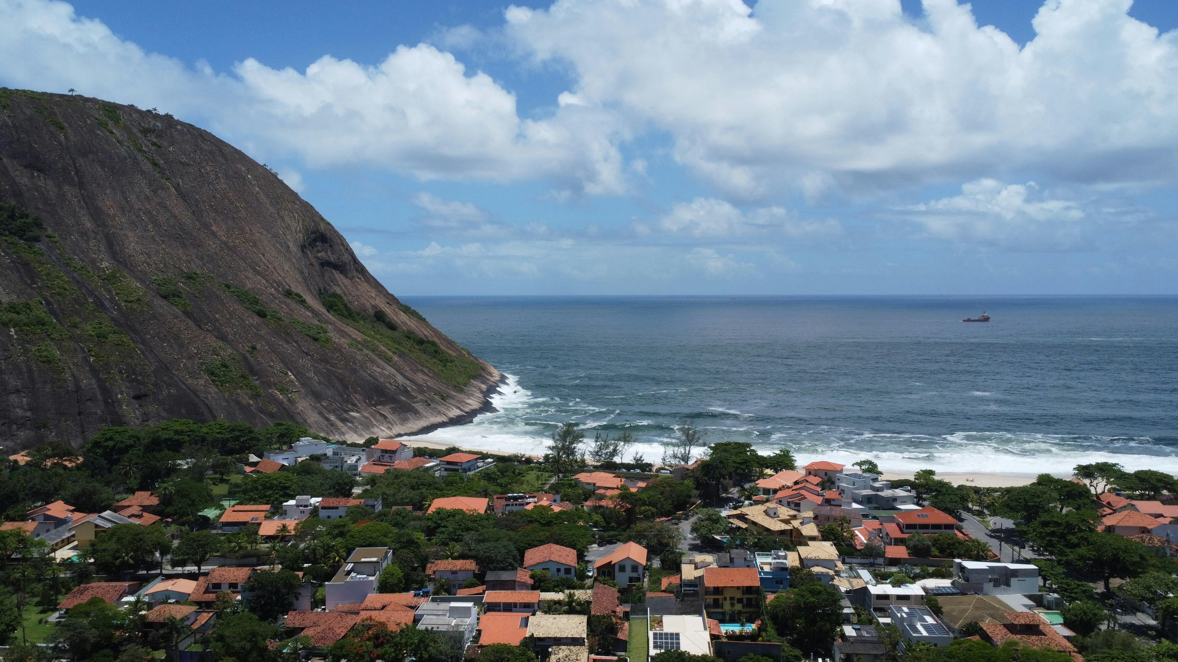 Una vista de una playa con una montaña al fondo foto – Imagen de Costa ...