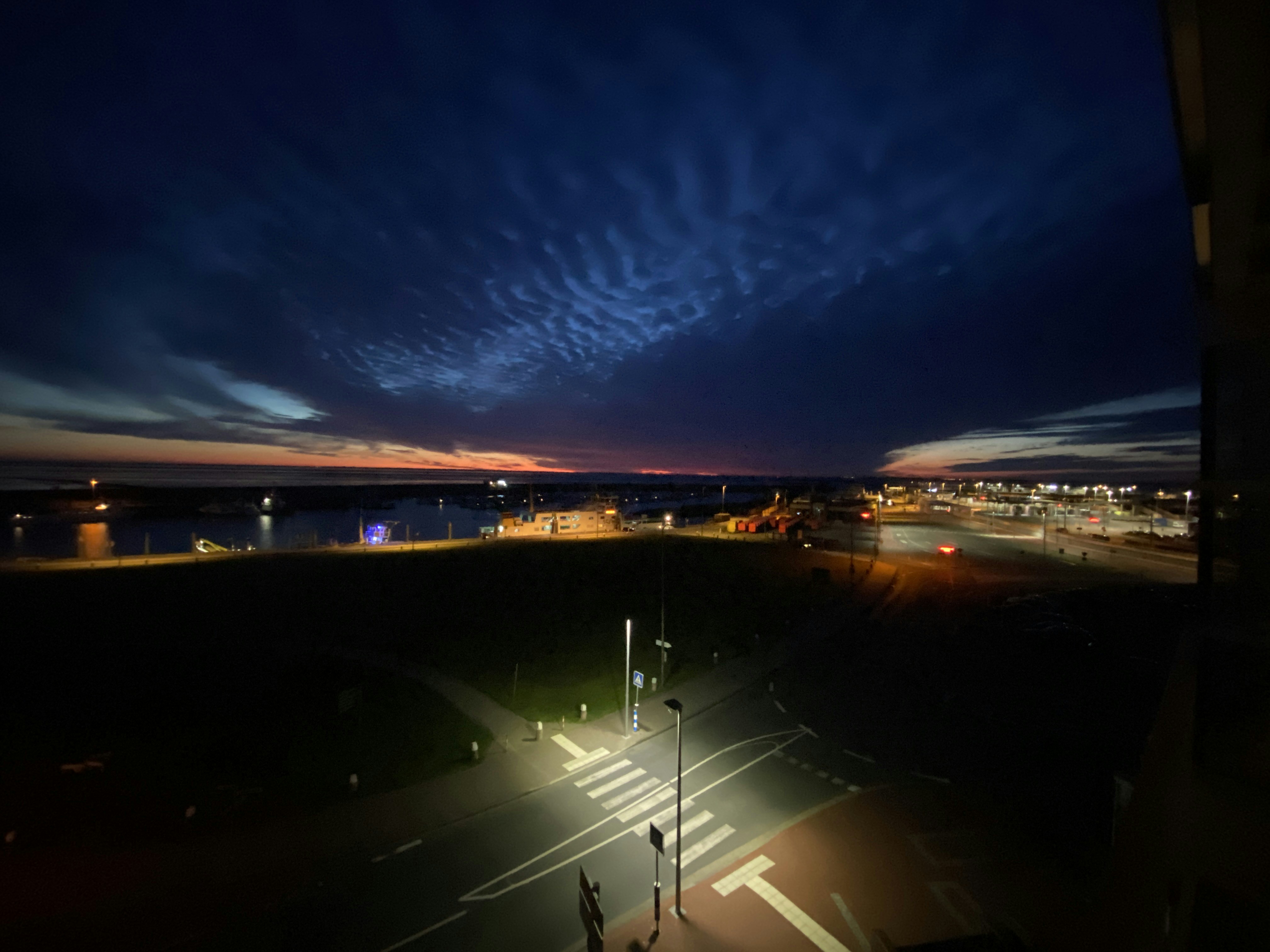 Crosswalk illuminated under a dramatic twilight sky in Northern Germany.