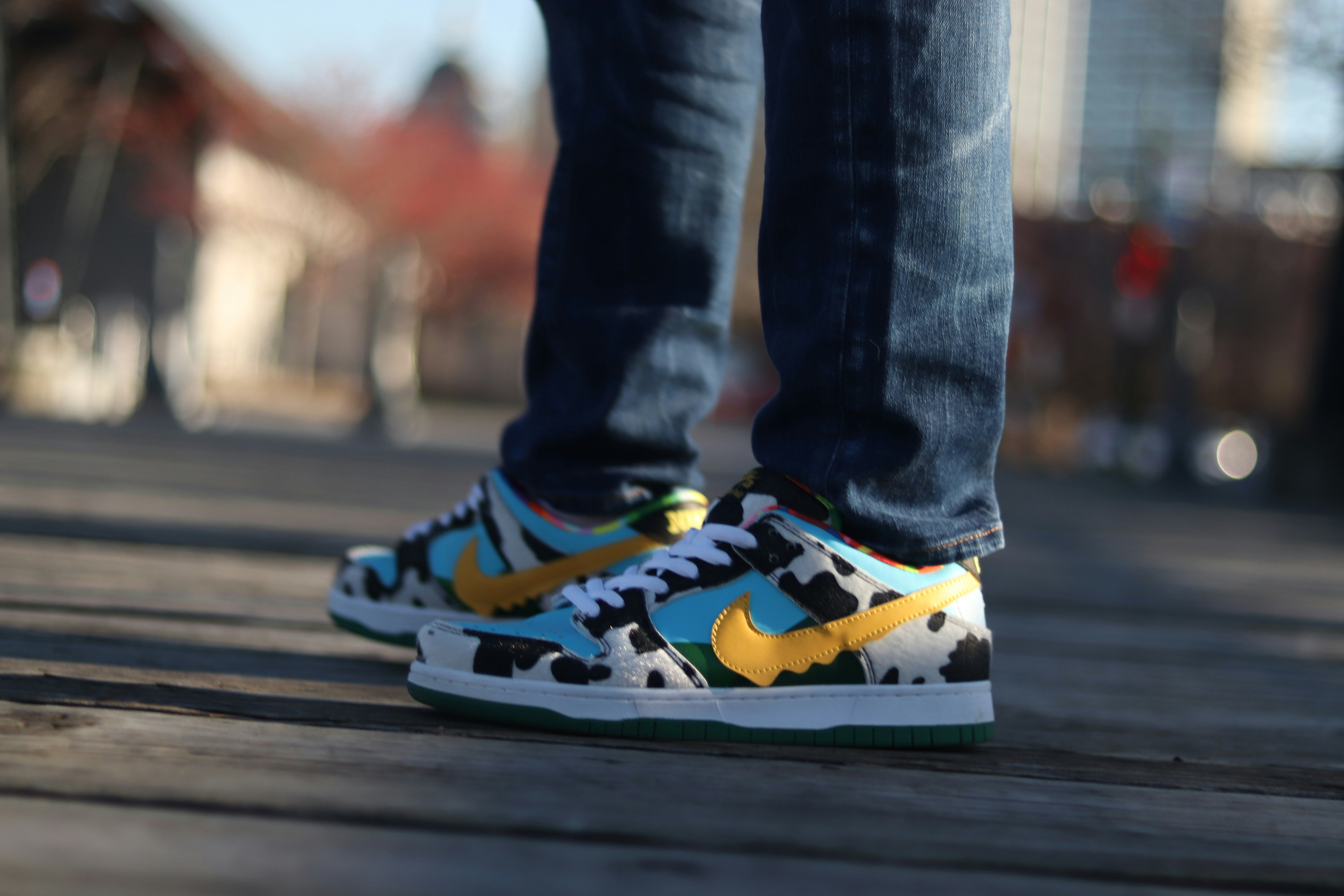 a person standing on a wooden floor wearing a pair of sneakers