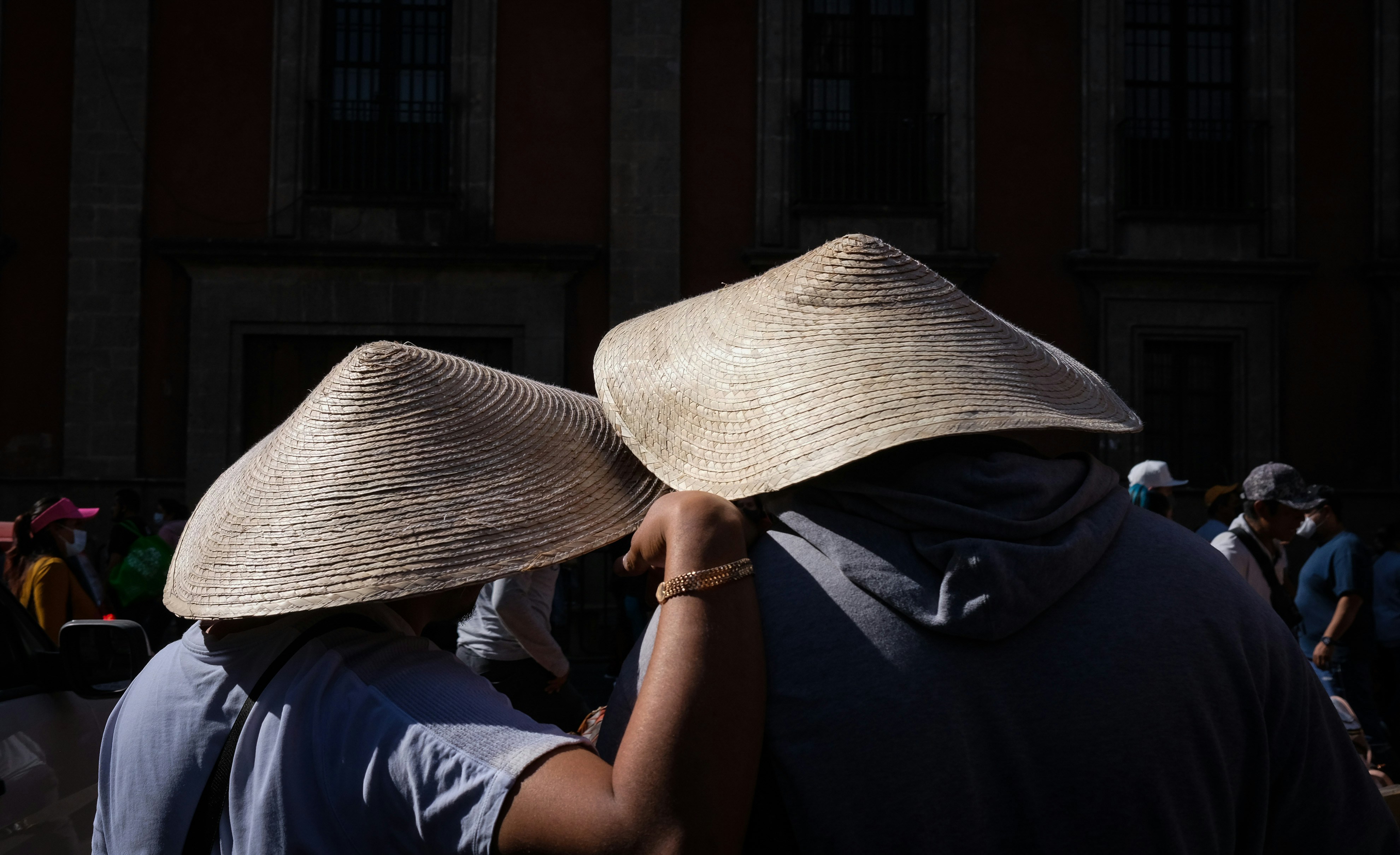 Straw Hats, Quiet Bond: A Moment in the Crowd