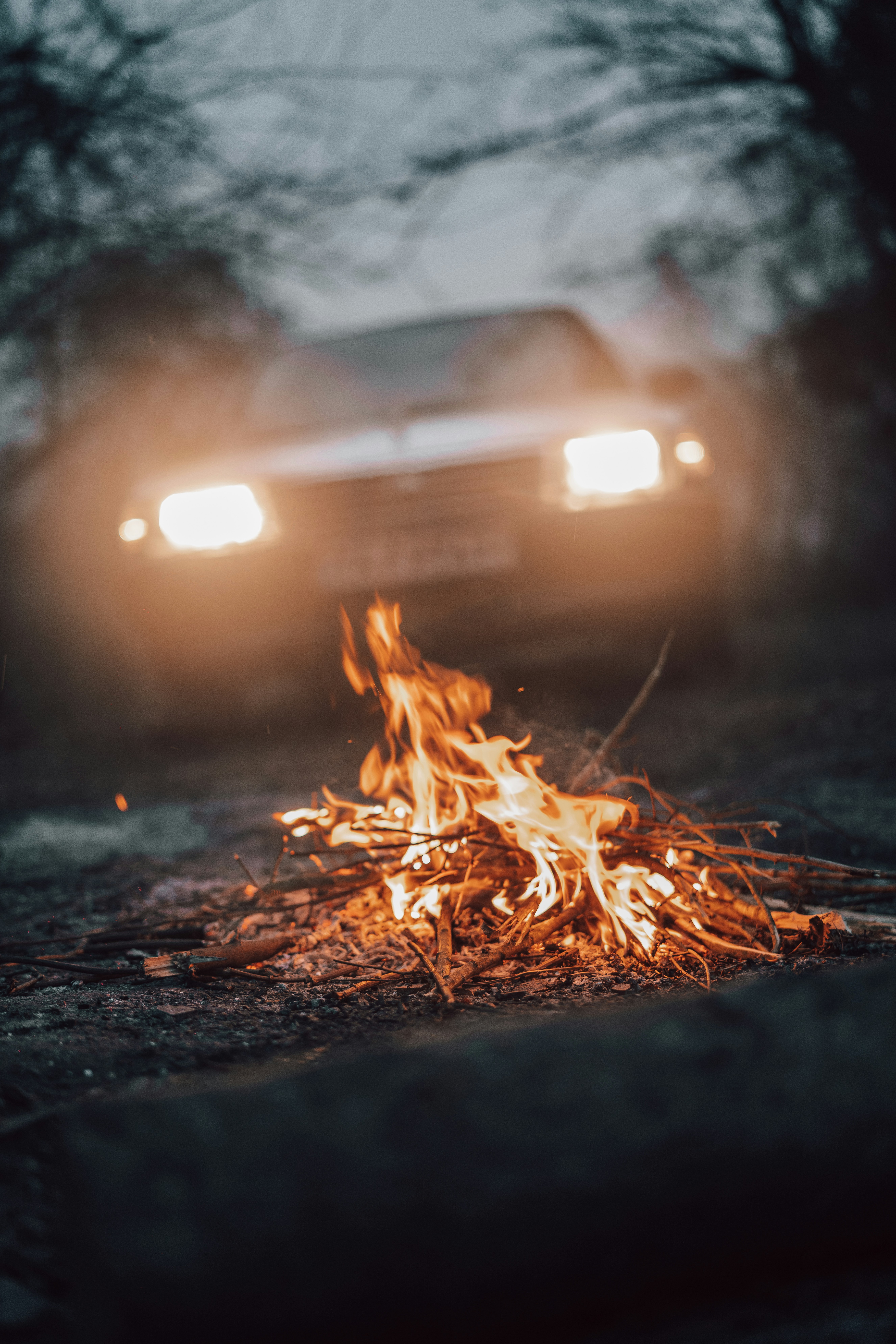 a car driving down a road next to a fire