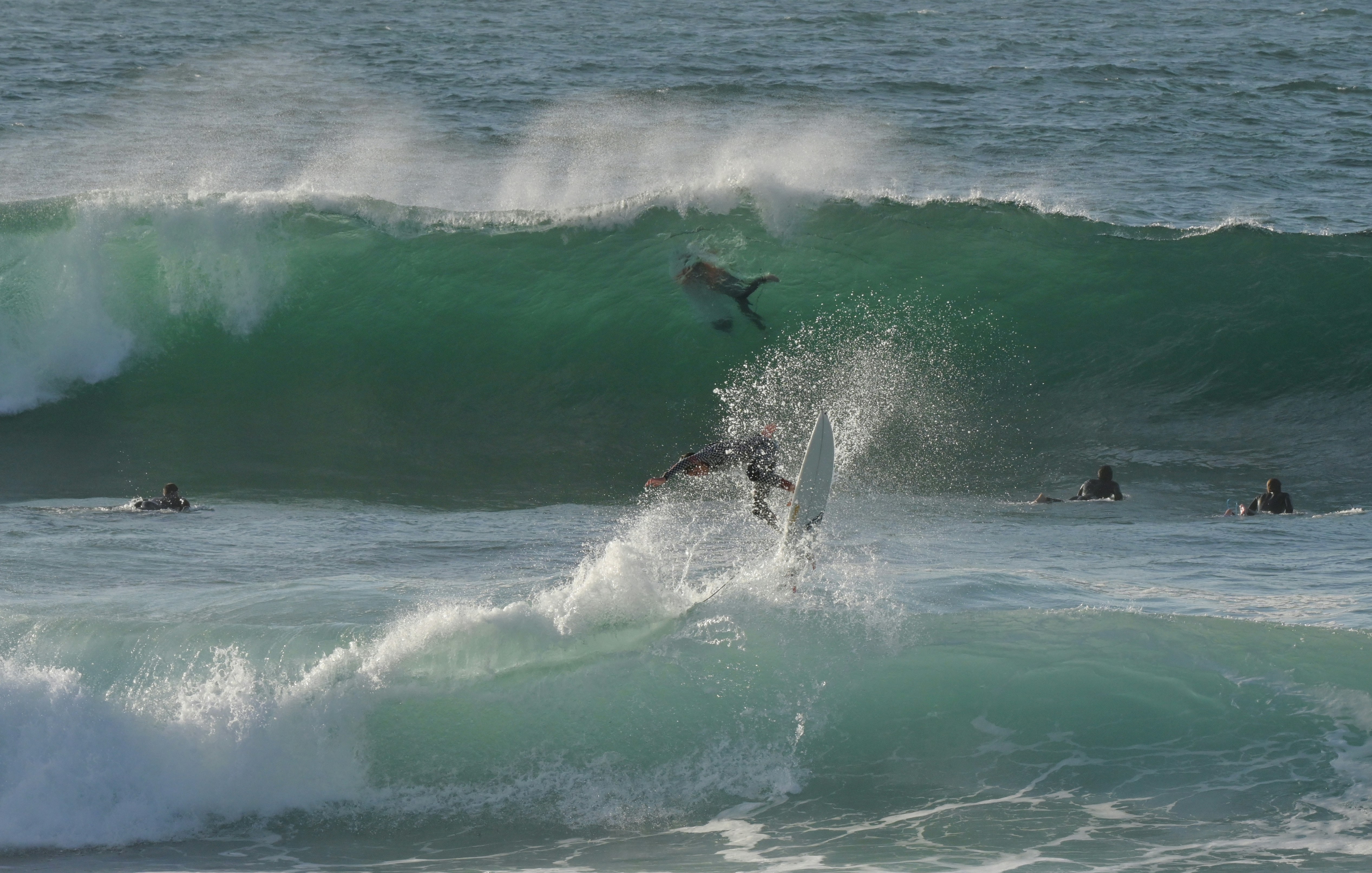A group of people riding waves on top of surfboards photo – Free Praia ...