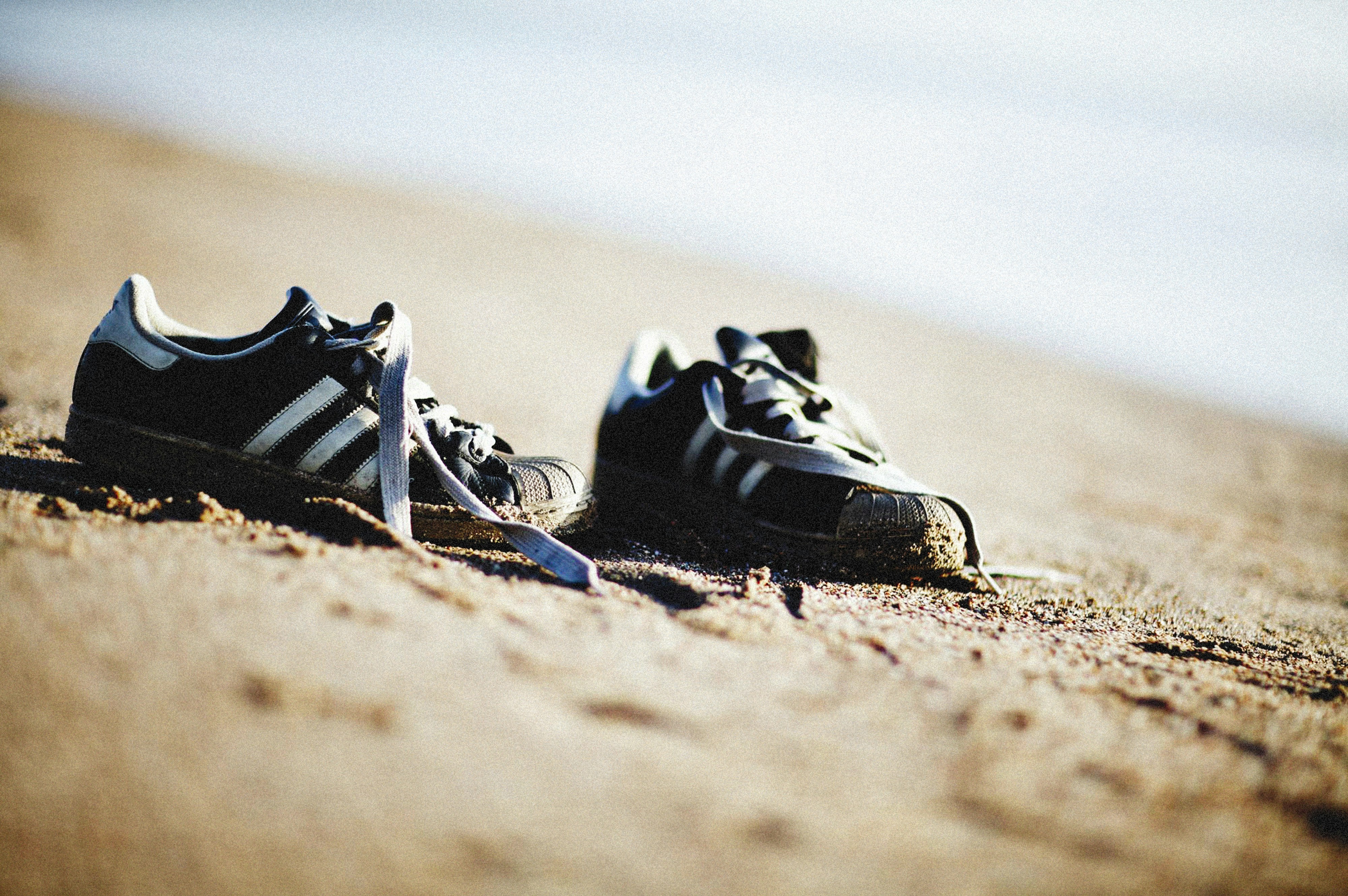 a pair of shoes that are on the sand
