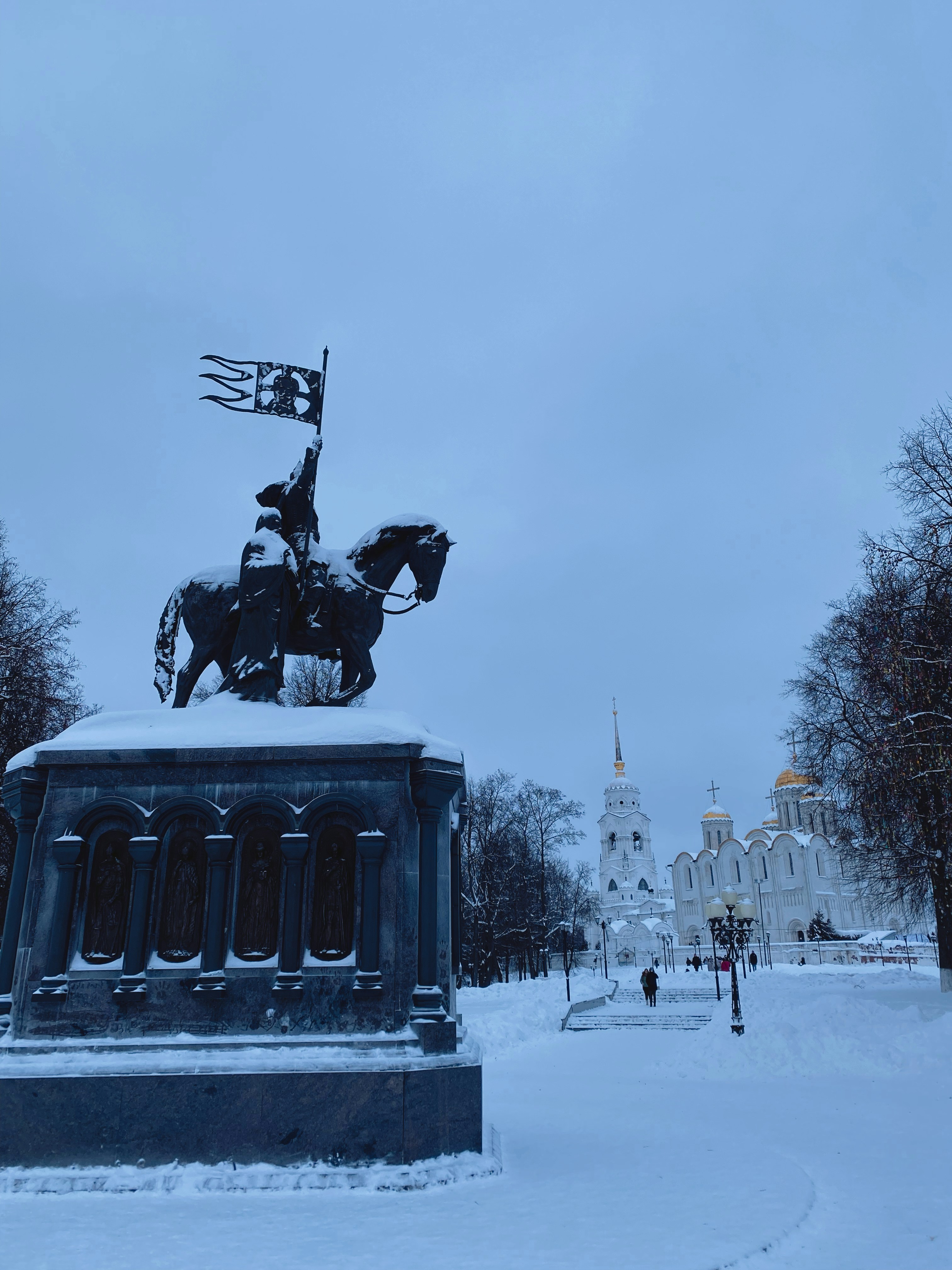 Flag Bearer in the Snow: A Frosted Cavalry Monument Framed by Orthodox Spires