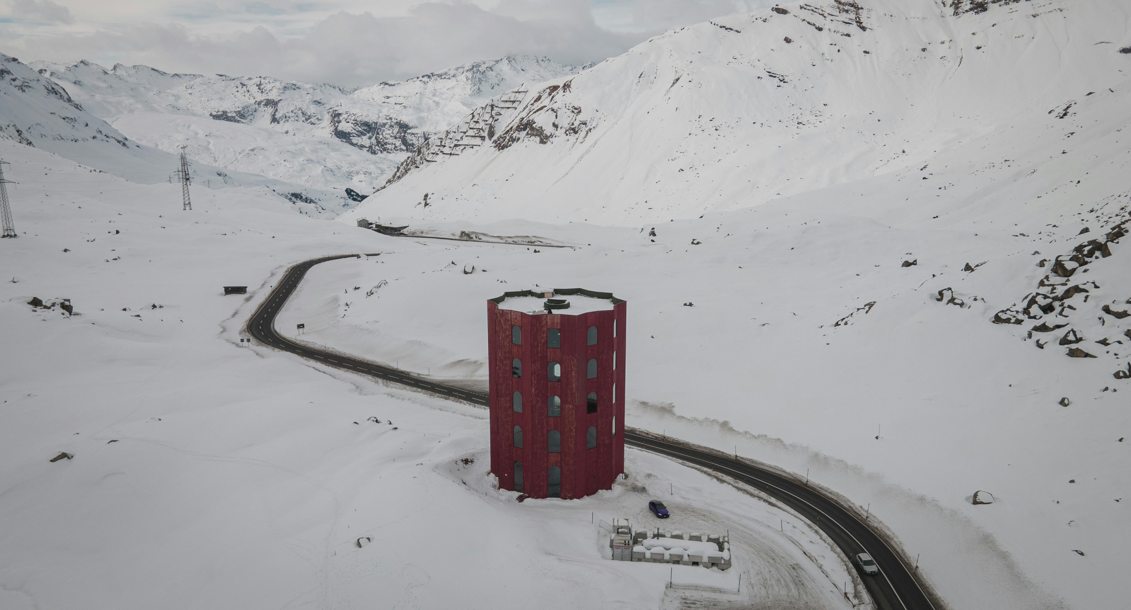 a red tower sitting on the side of a snow covered mountain