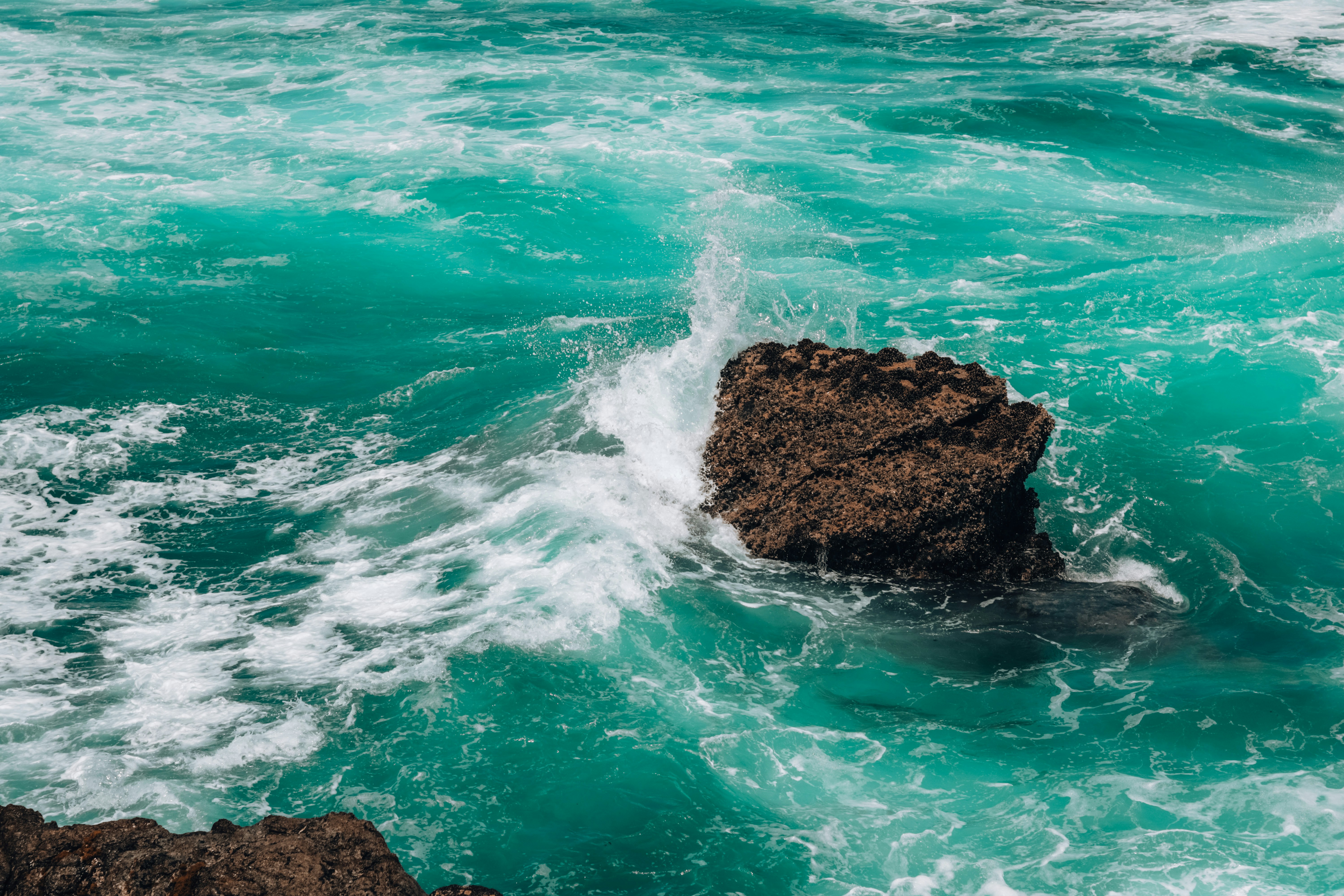 Foto Una roca que sobresale del agua del océano – Imagen Ecuador gratis ...