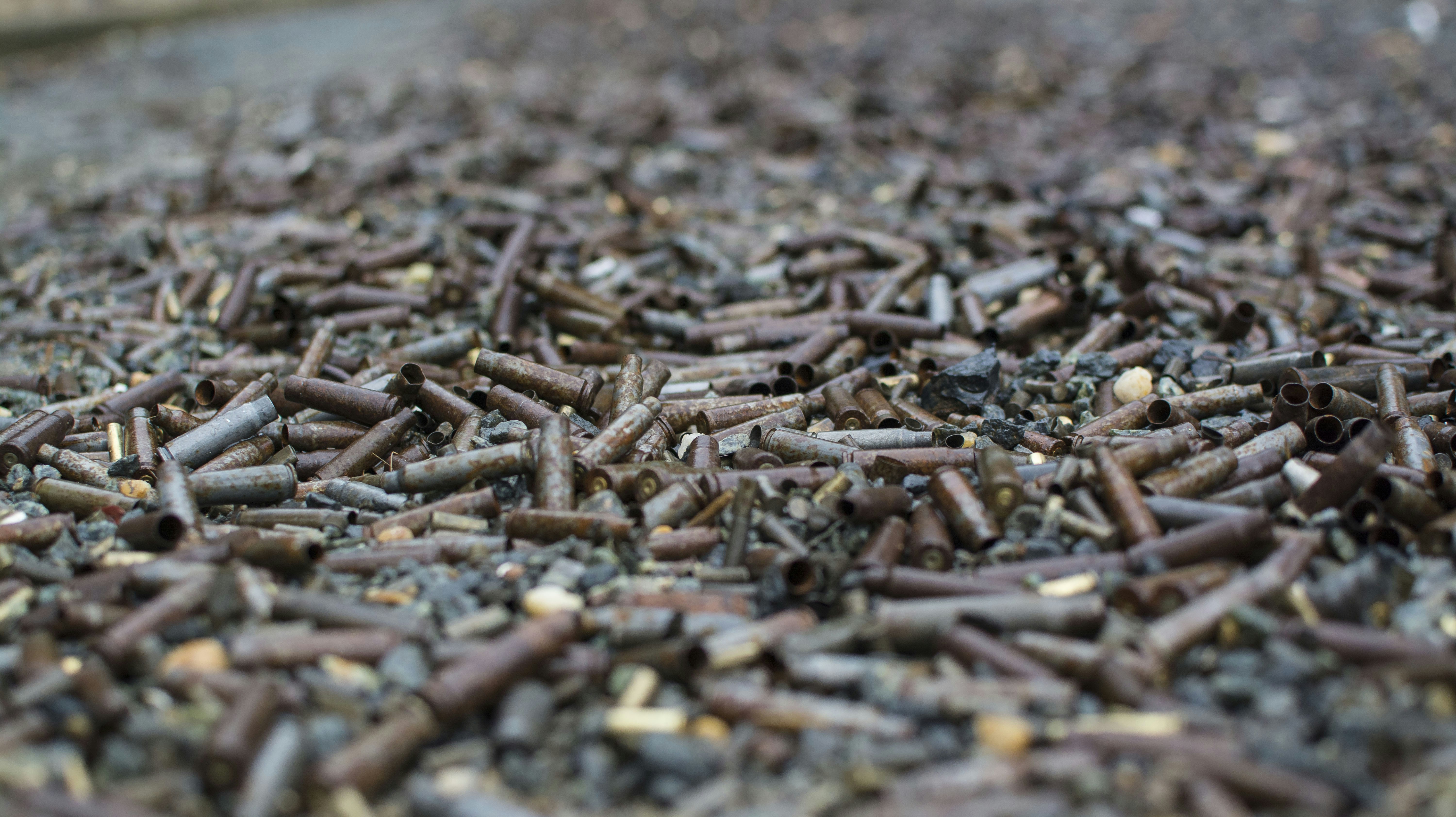 A detailed view of scattered metal tubes and debris on a ground surface, showcasing the passage of time and neglect.