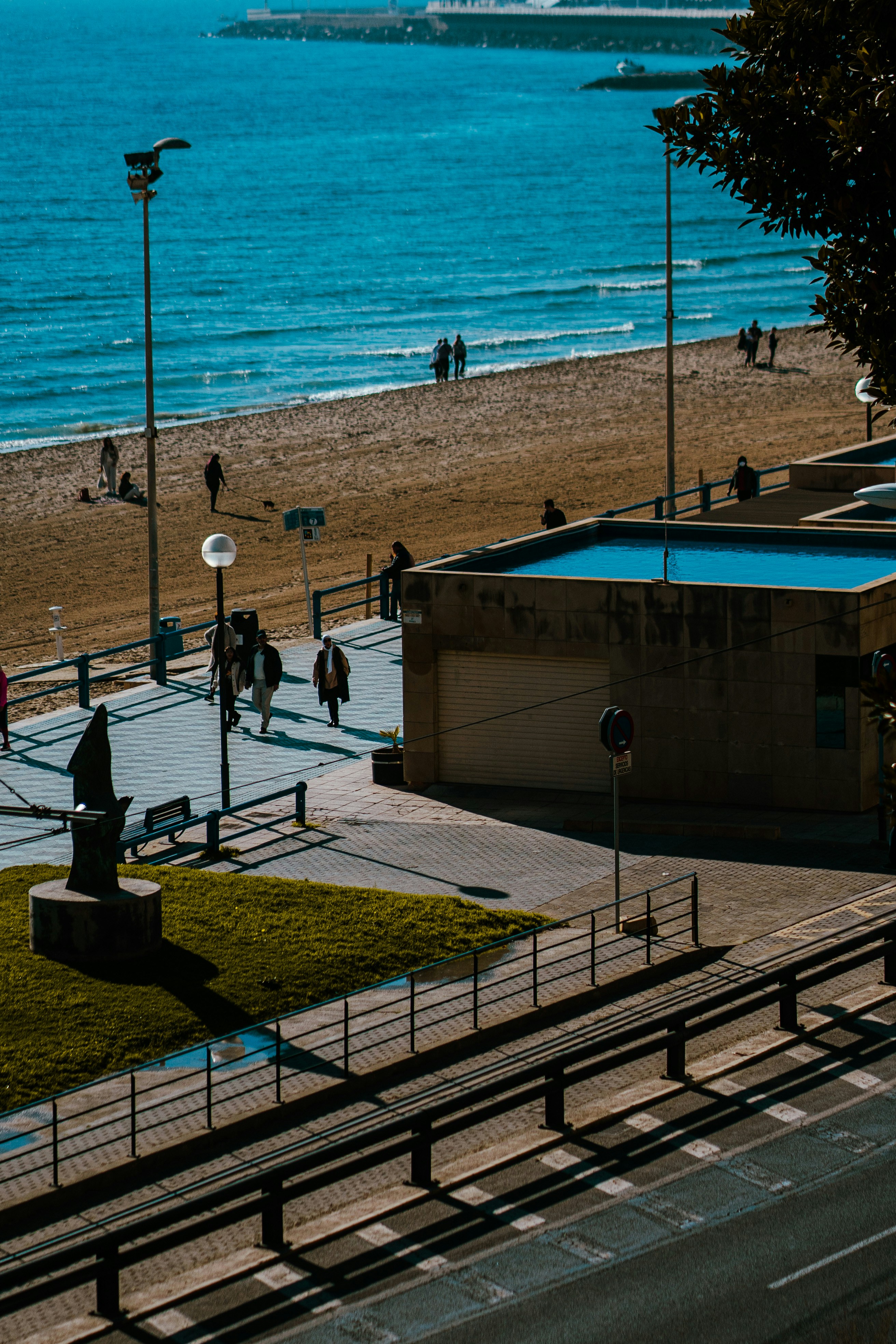 a view of a beach with people walking on it