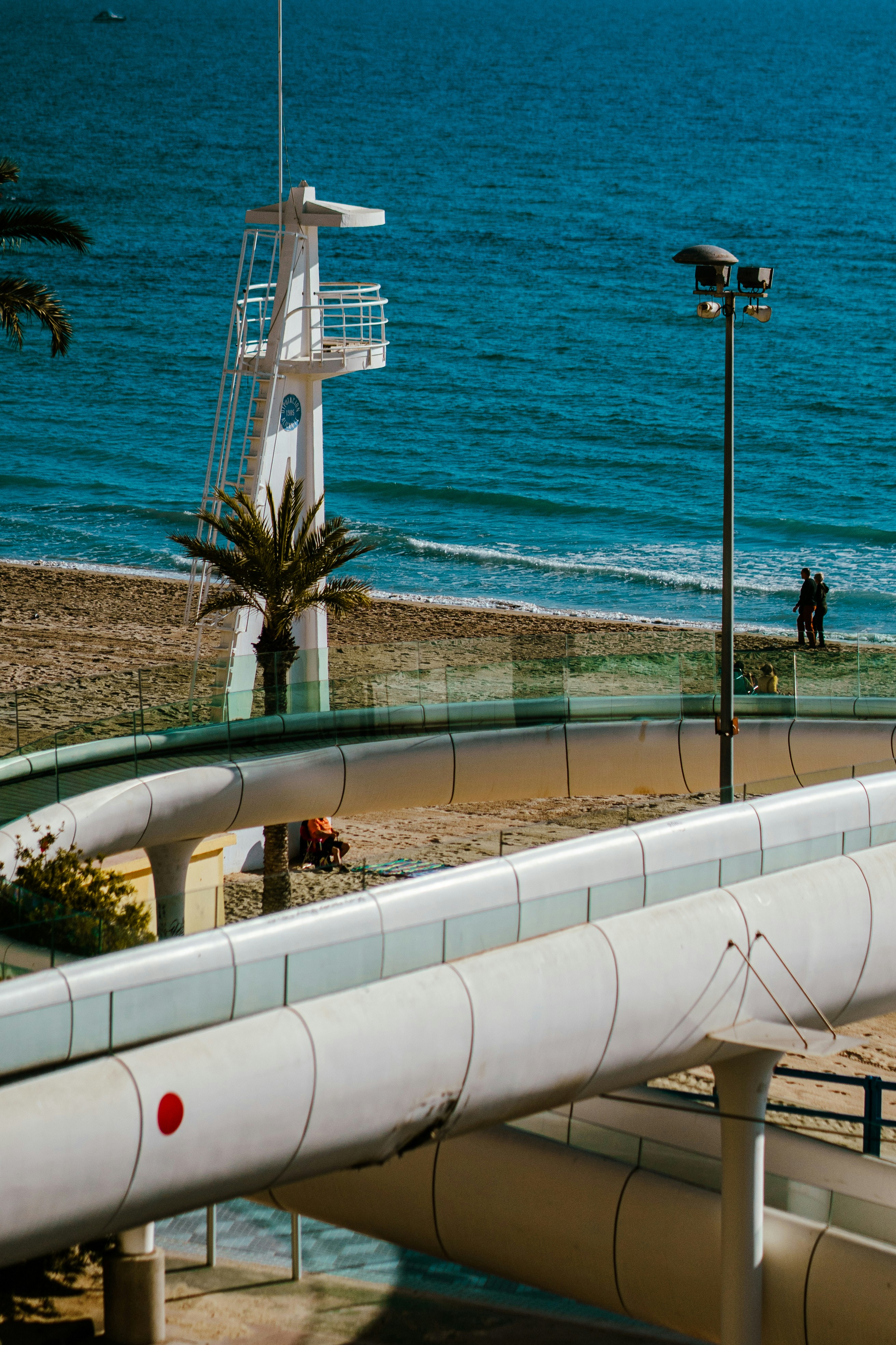 A slide on a beach next to the ocean photo – Free Alicante Image on ...