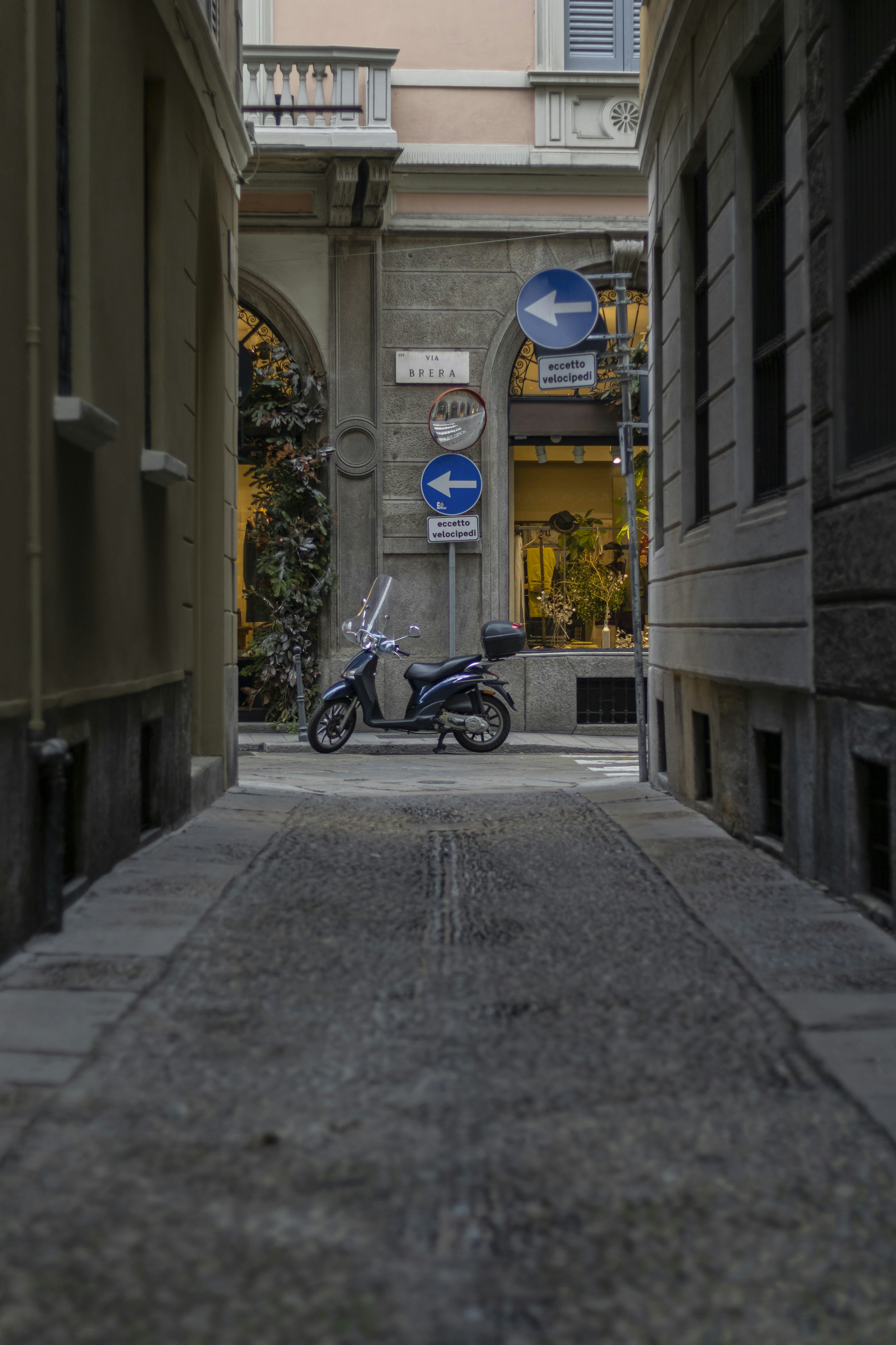 A motorcycle is parked in an alley between two buildings photo – Free ...