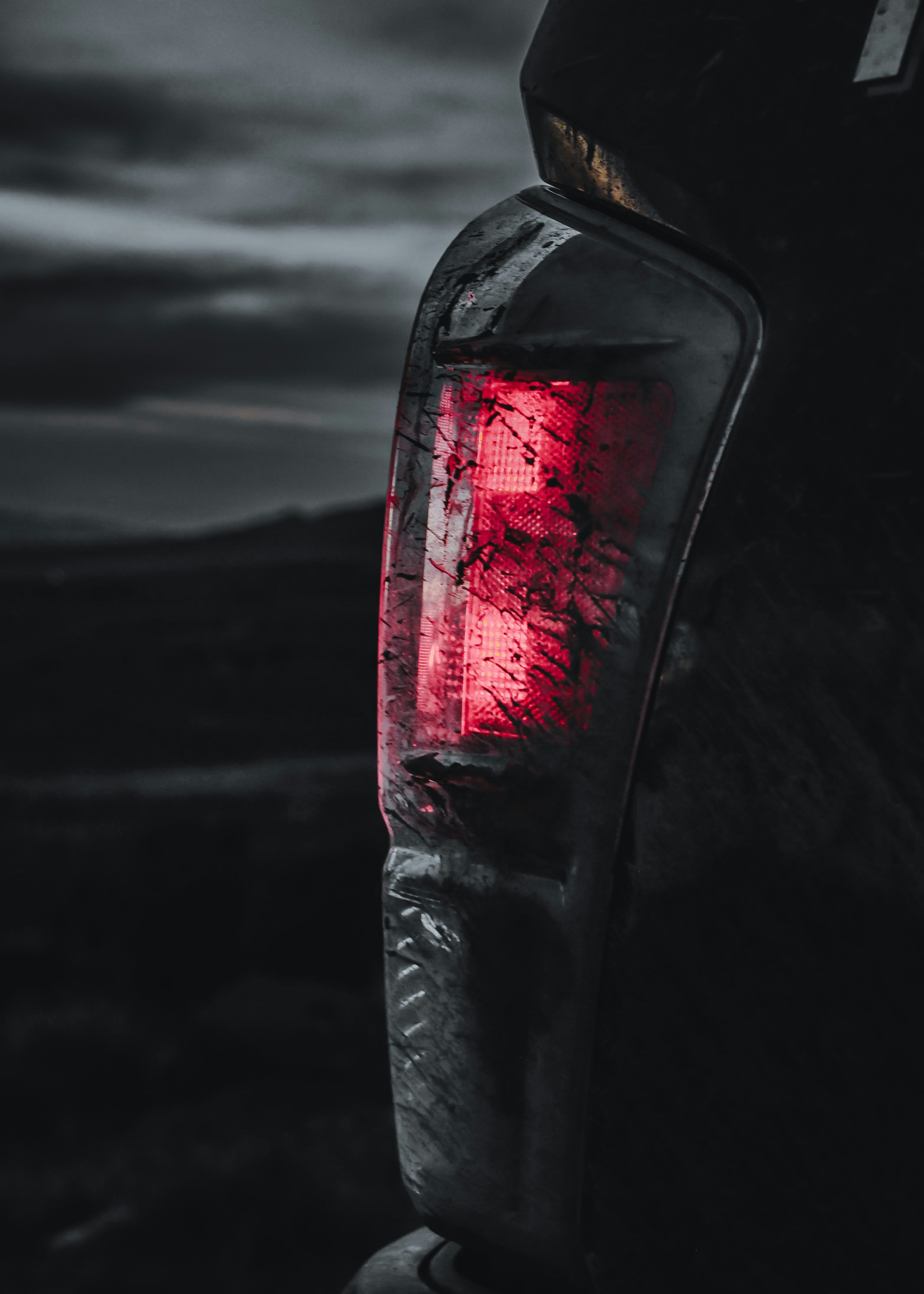 Crimson Tail Light Amid Midnight Landscape