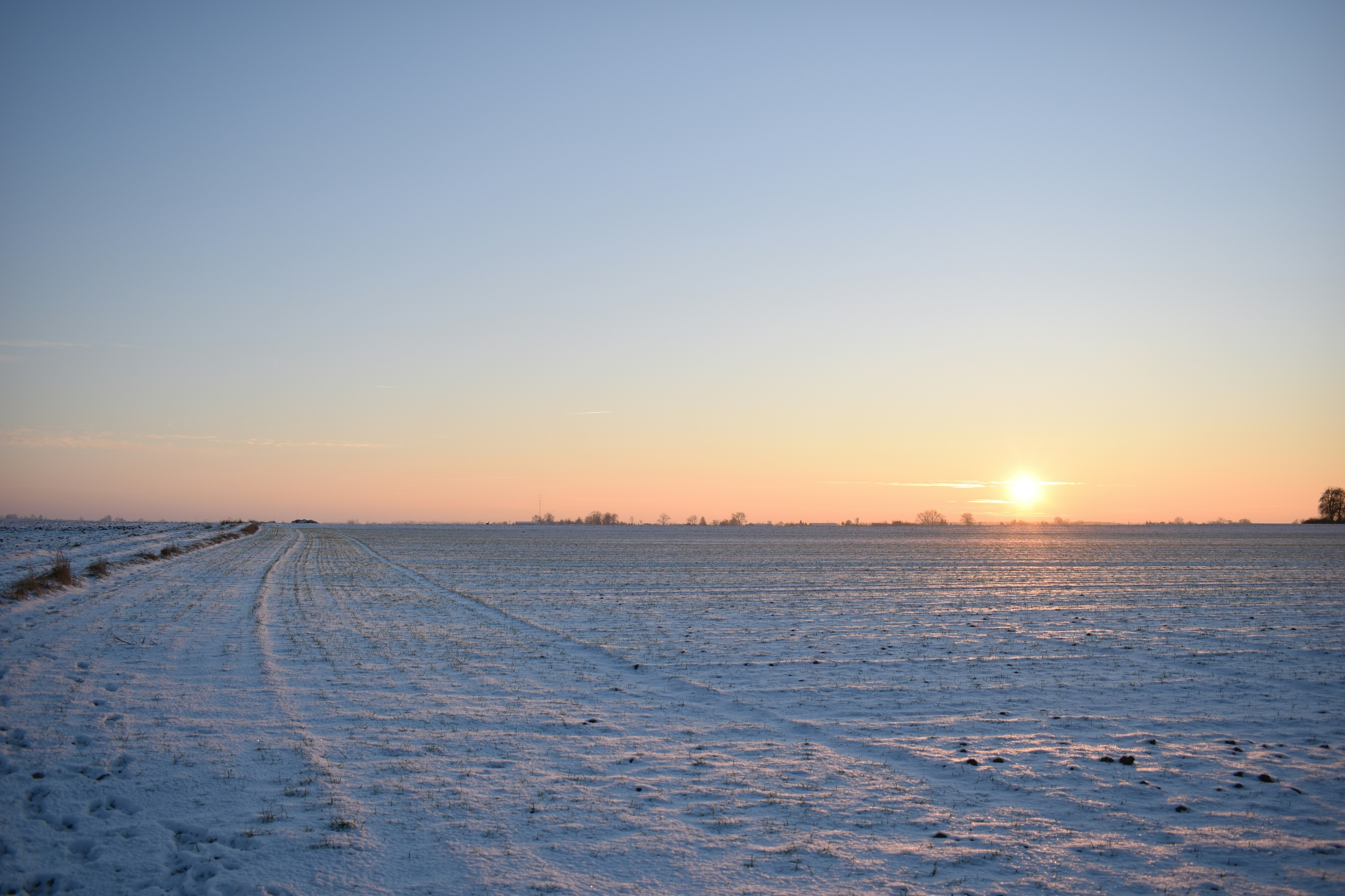 Sunset Over the Snowfield: A Lone Track Bends Toward the Quiet Horizon