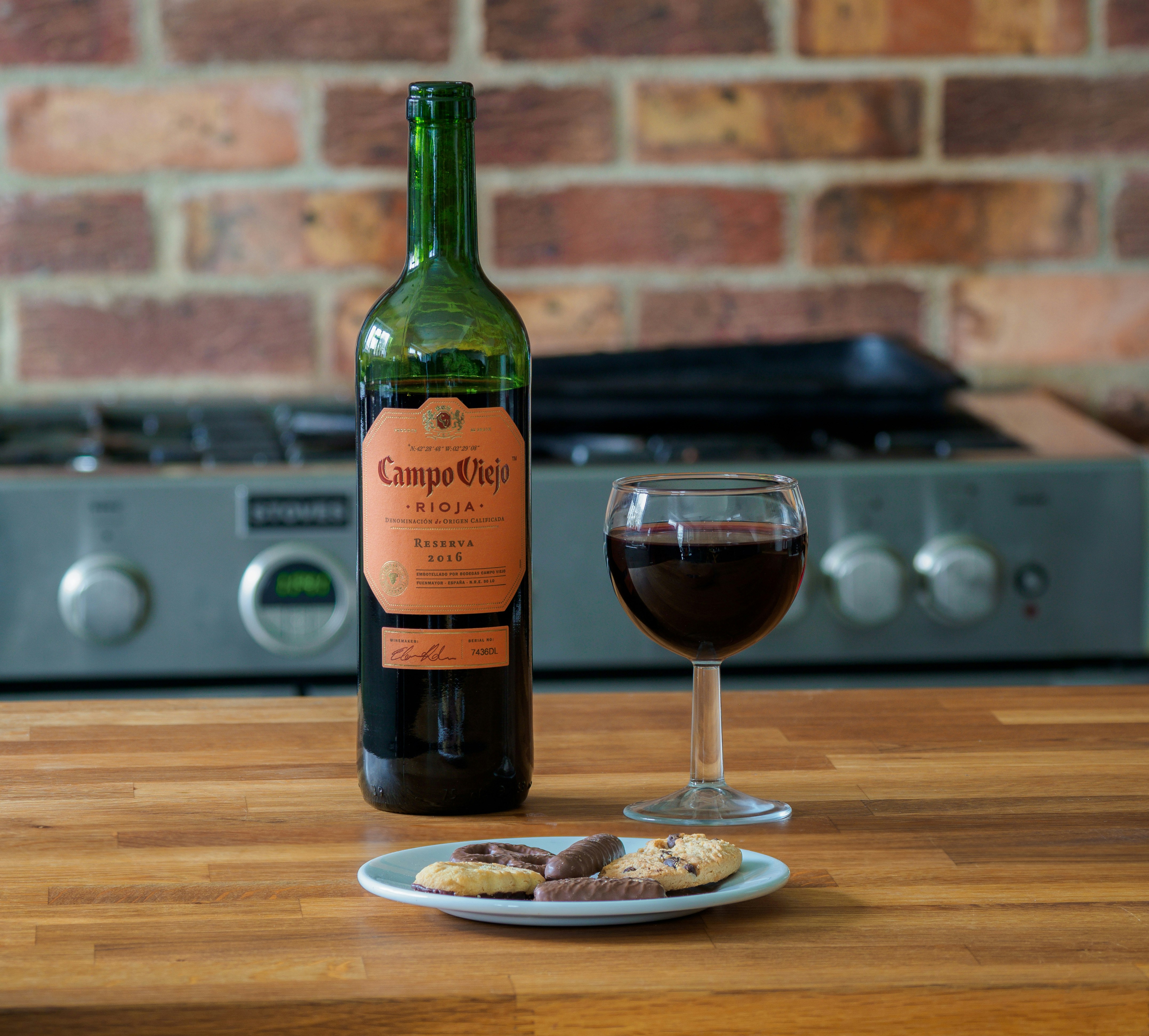 A bottle of wine and a glass of wine on a table photo – Free Wine Image ...