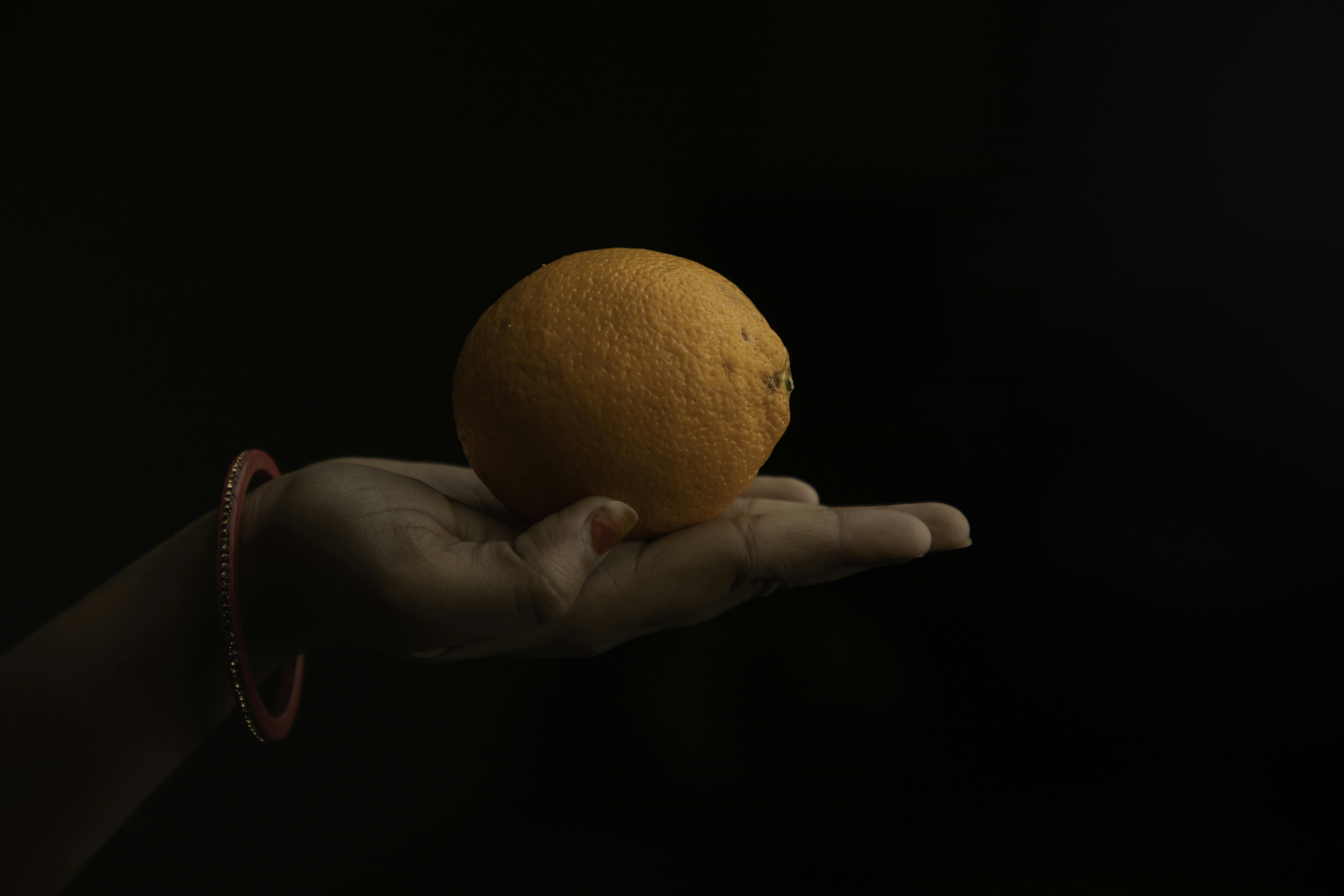 Solitary Orange in Velvet Darkness: A Quiet Palm Study