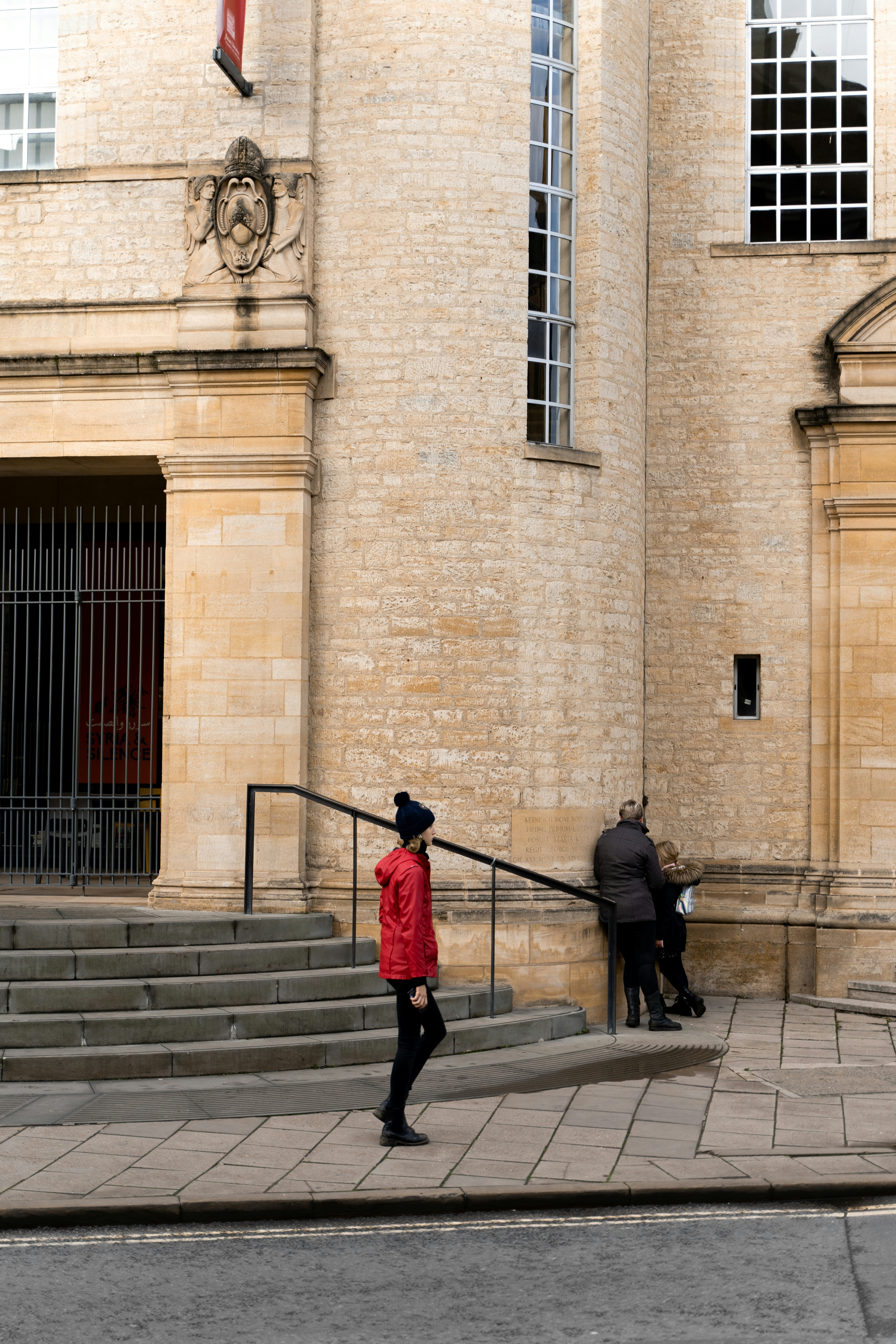 a person walking down a sidewalk in front of a brick building