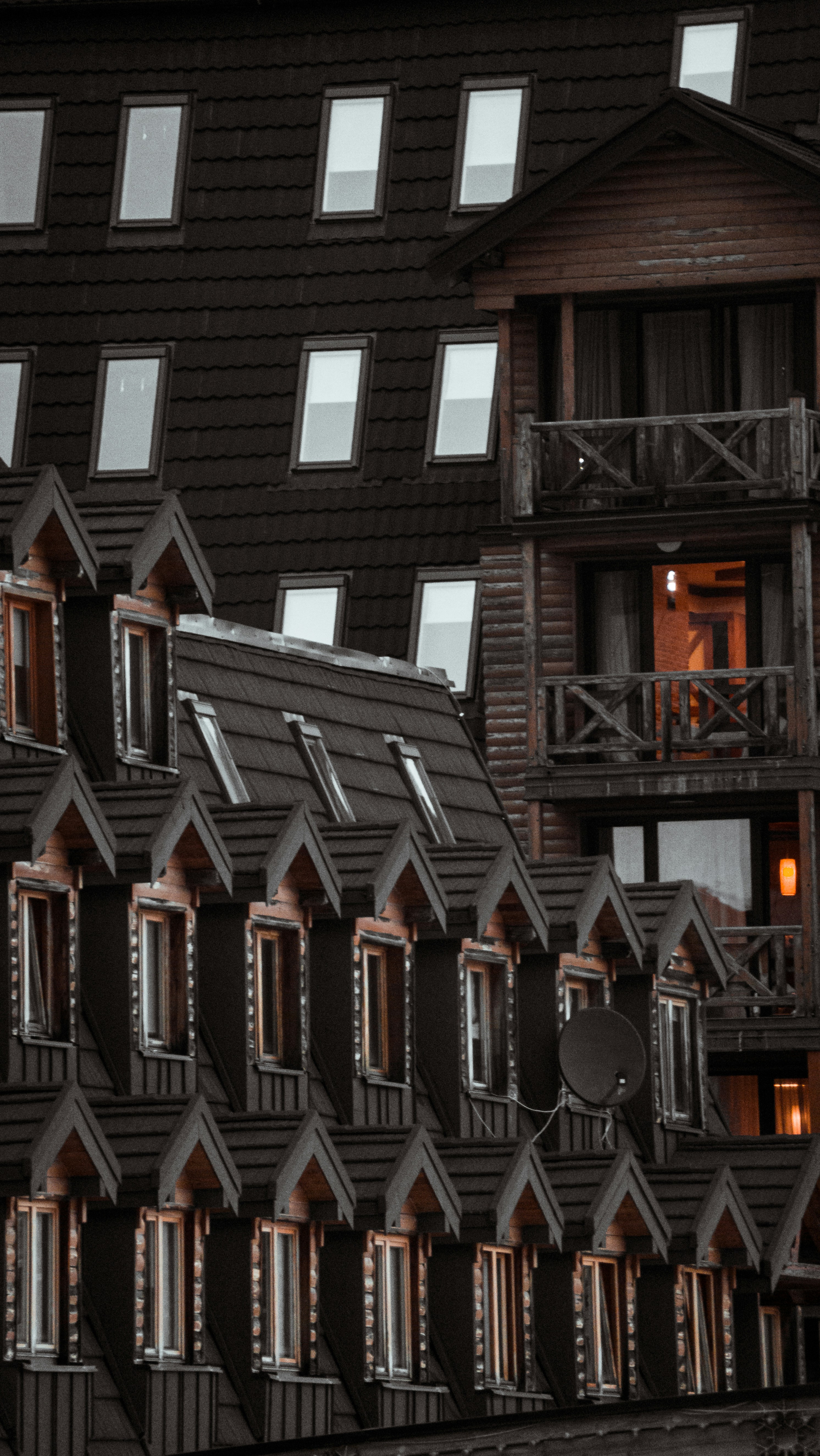 Warm Windows Among Timber Dormers: A Nordic Lodge Facade at Dusk