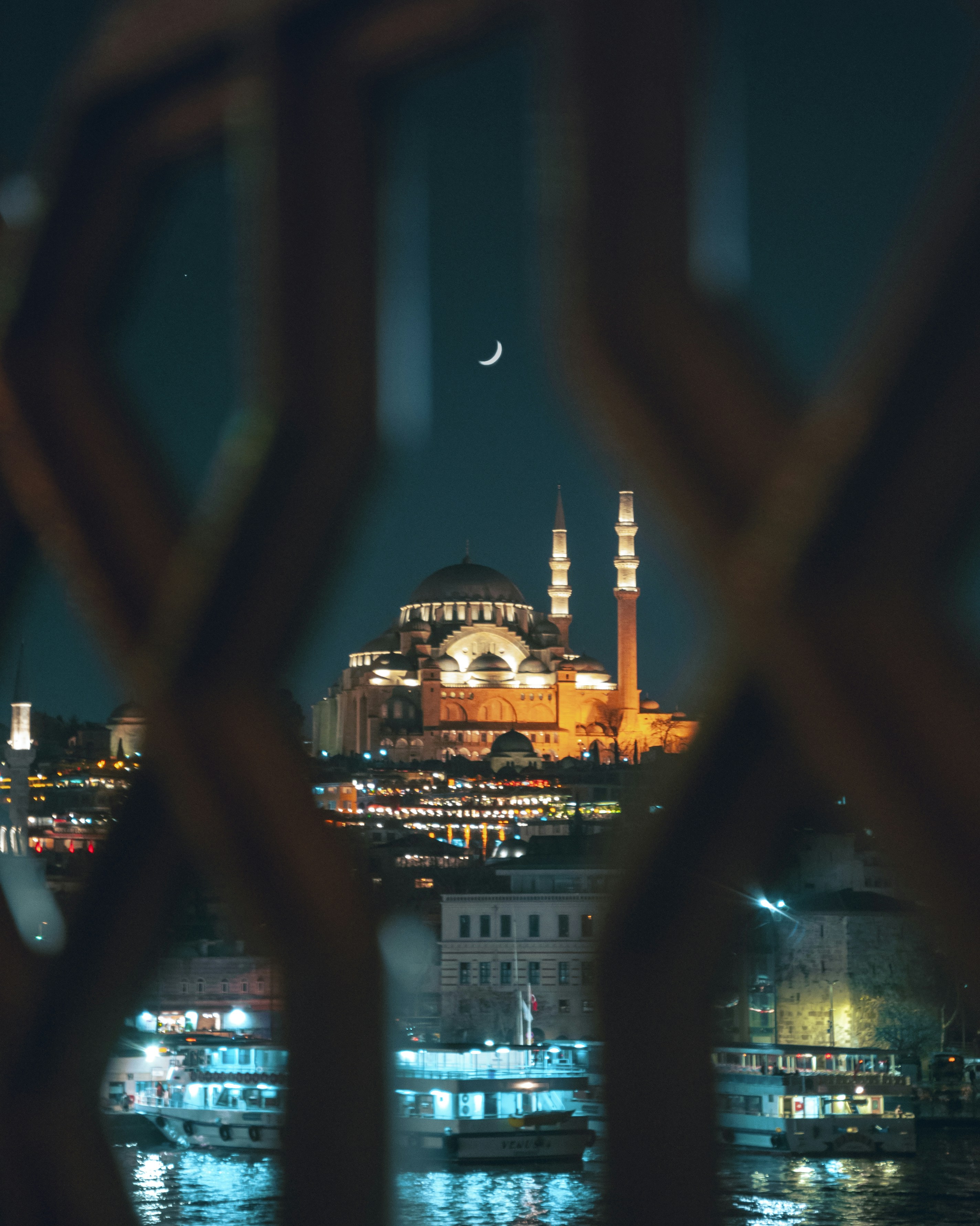 Moonlit Crescent Over Istanbul's Domed Skyline Framed by Ironwork