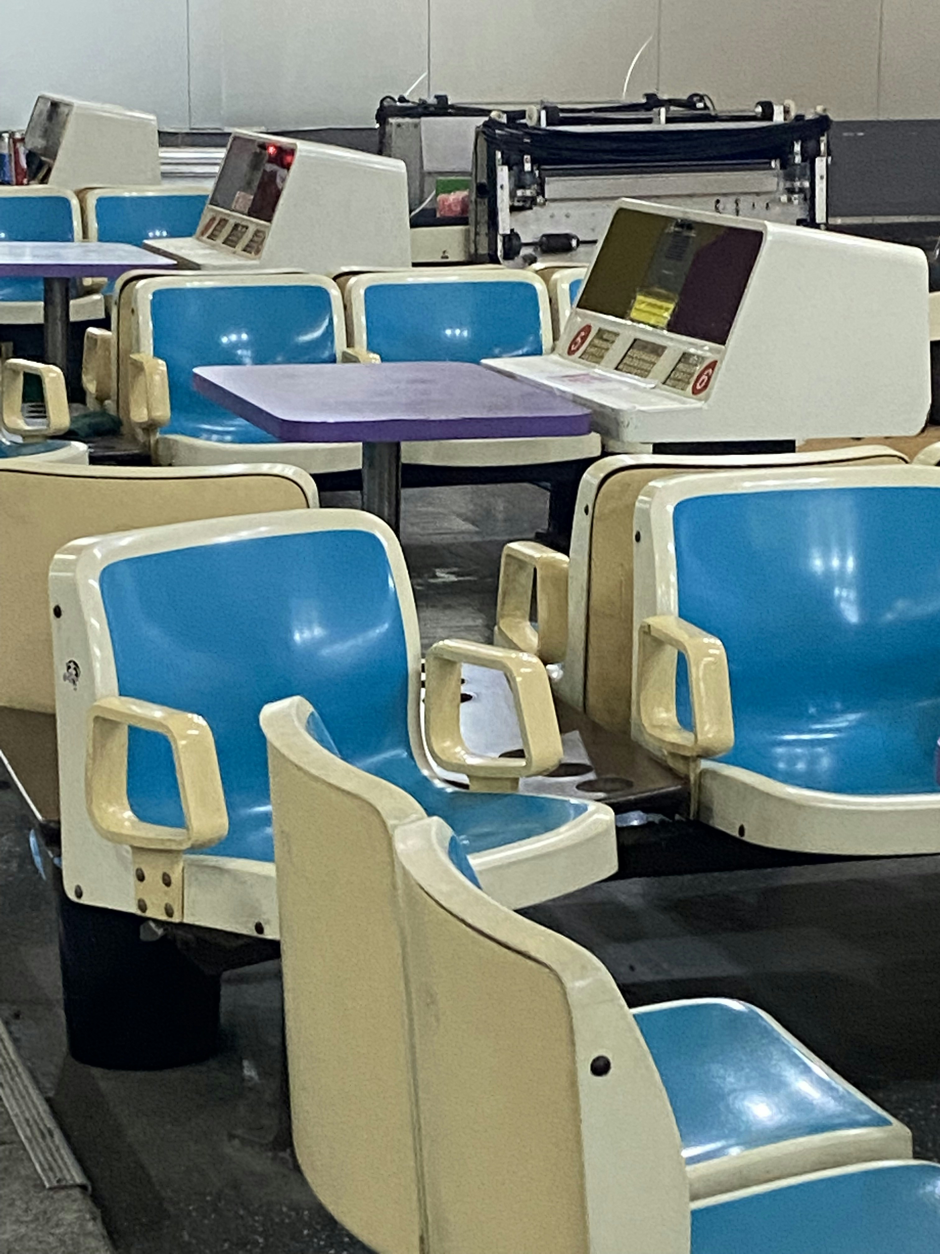 Quiet Retro Bowling Alley: A Violet Table Anchors a Sea of Turquoise Seats