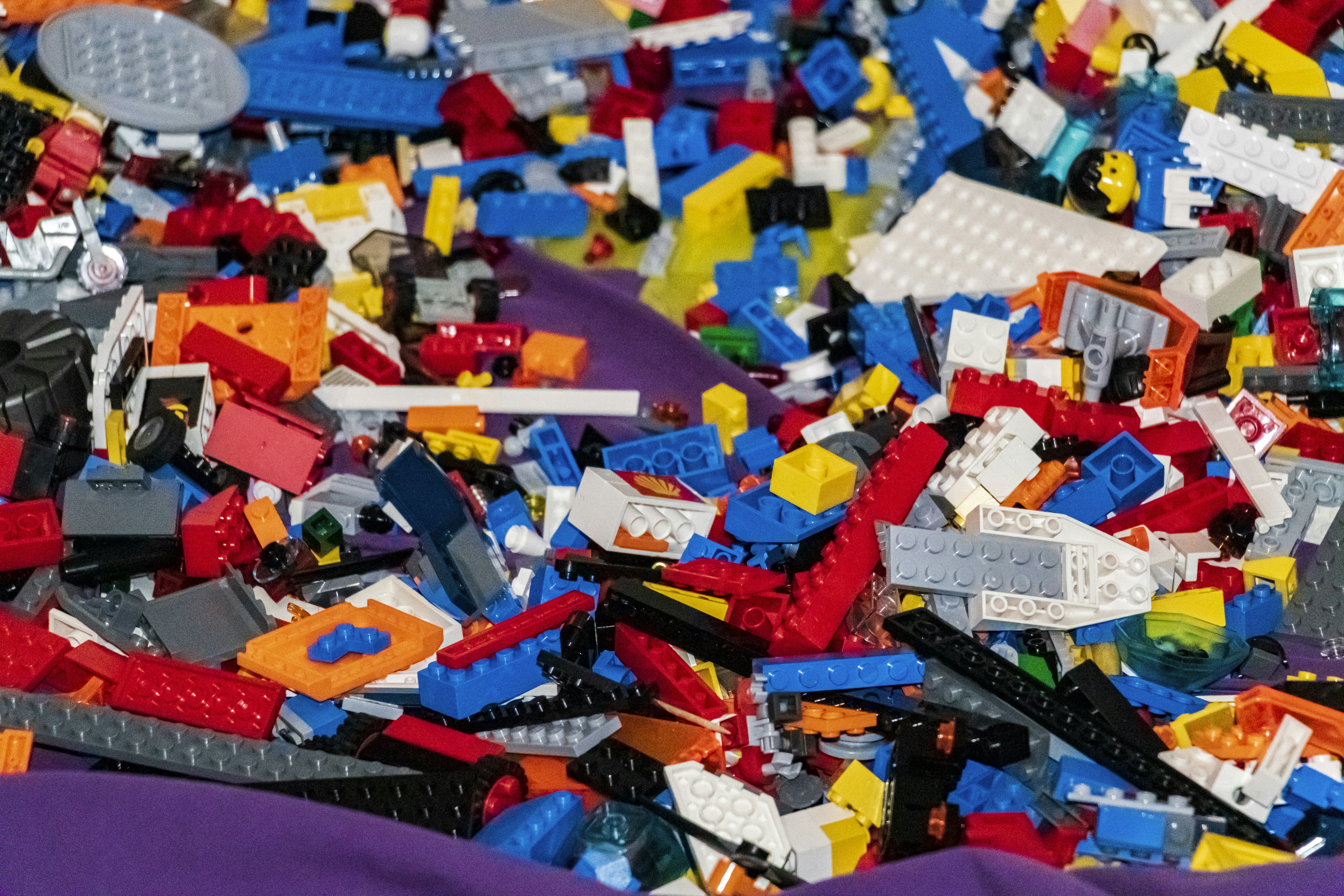 A pile of assorted legos sitting on top of a purple blanket photo ...