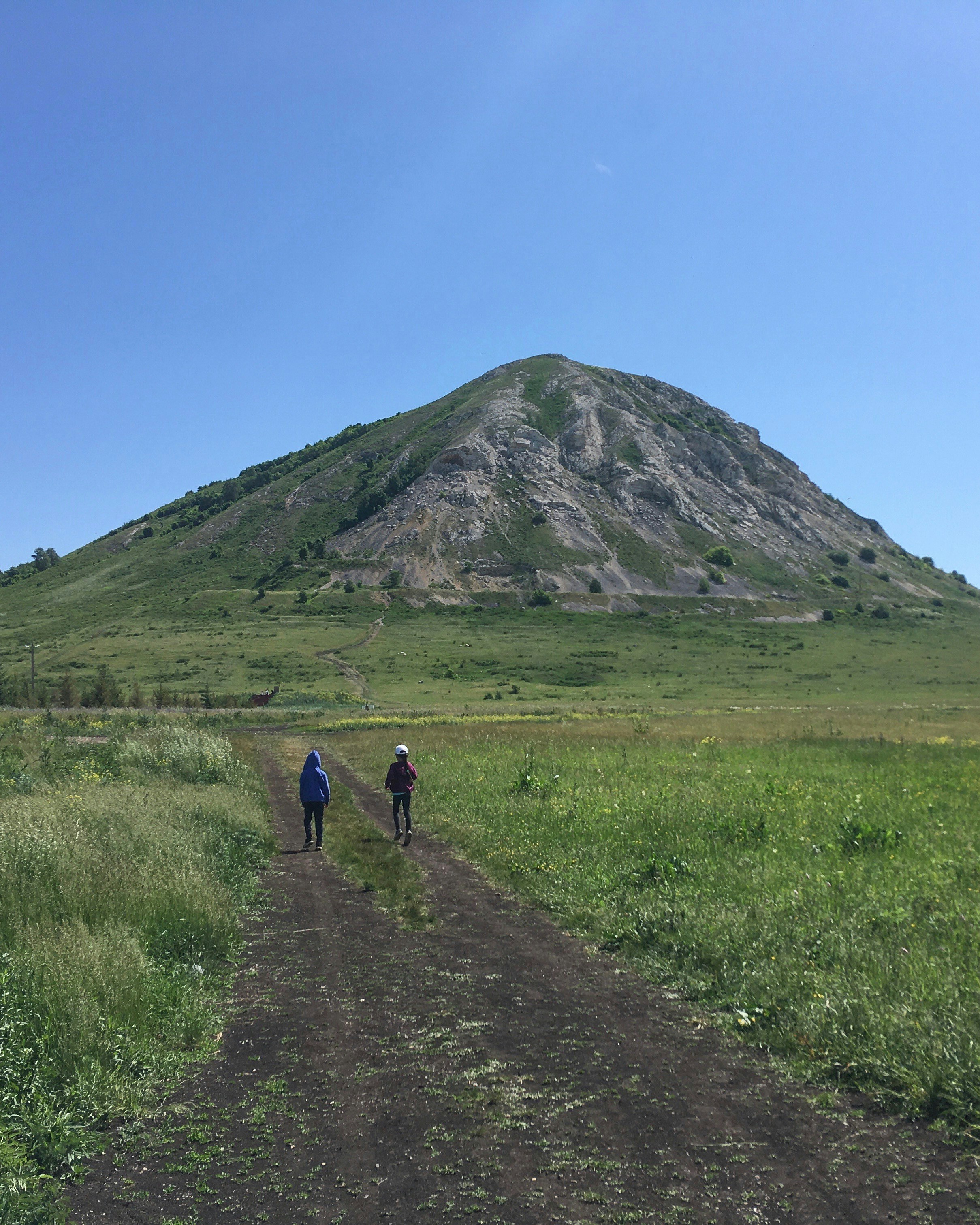 A couple of people walking down a dirt road photo – Free Human Image on ...