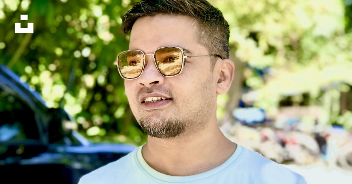 Foto Un Hombre Con Gafas De Sol Parado Frente A Un Coche Imagen