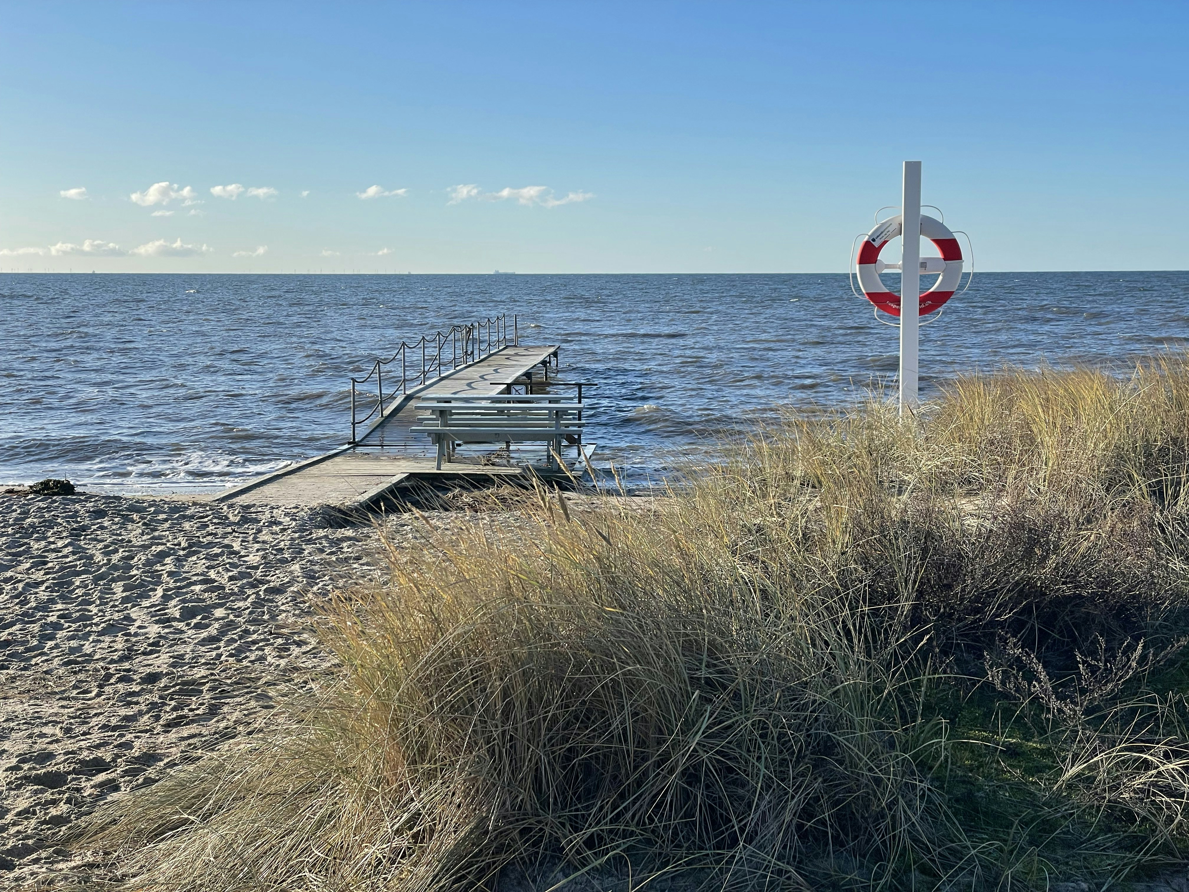 a bench on a beach next to a body of water
