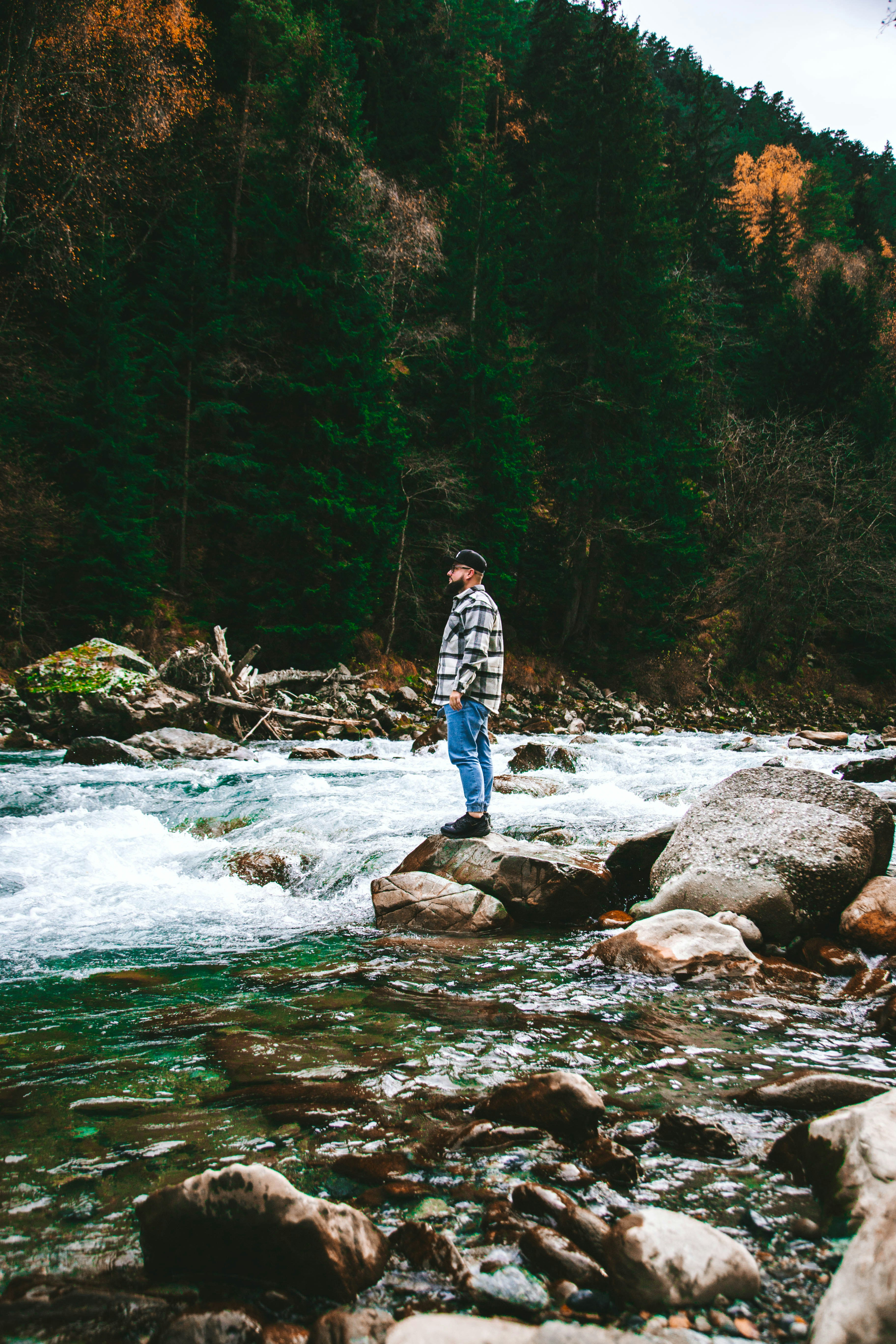 Un homme debout sur un rocher au milieu d’une rivière photo – Photo Le ...