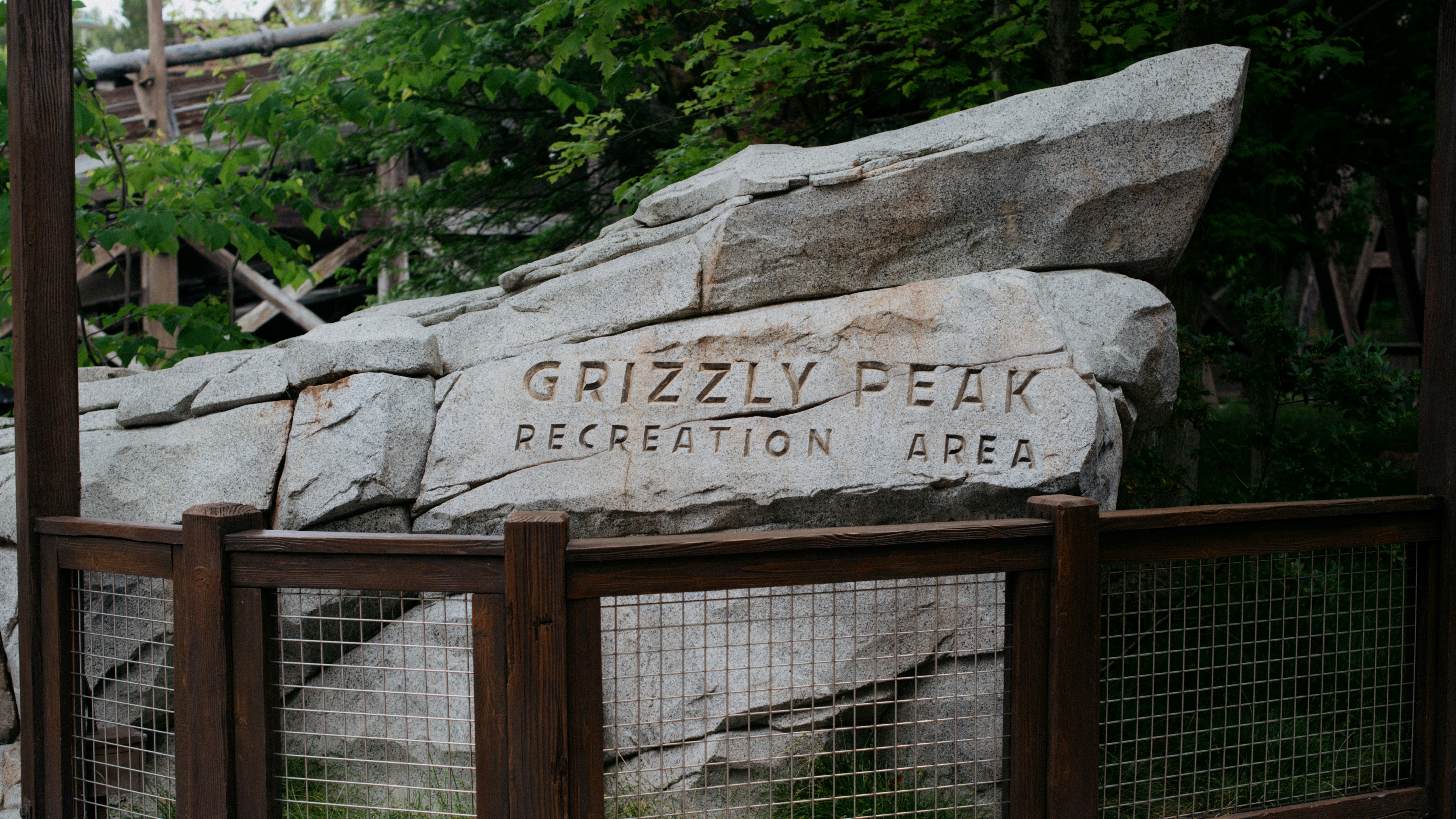 Rock formation engraved with 'GRIZZLY PEAK RECREATION AREA' surrounded by lush greenery.