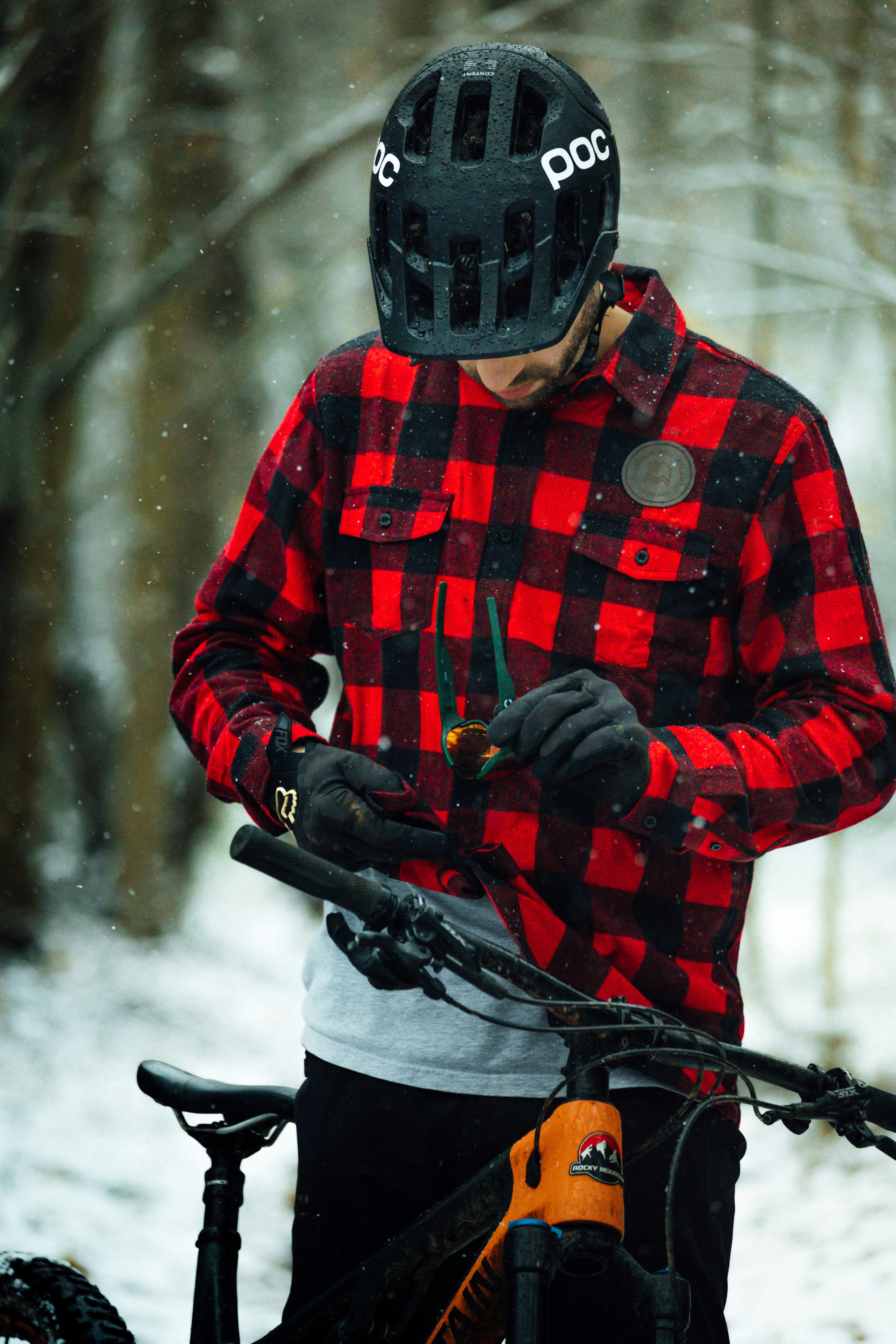 Bunker of focus: a cyclist adjusts gear in a snowy woodland