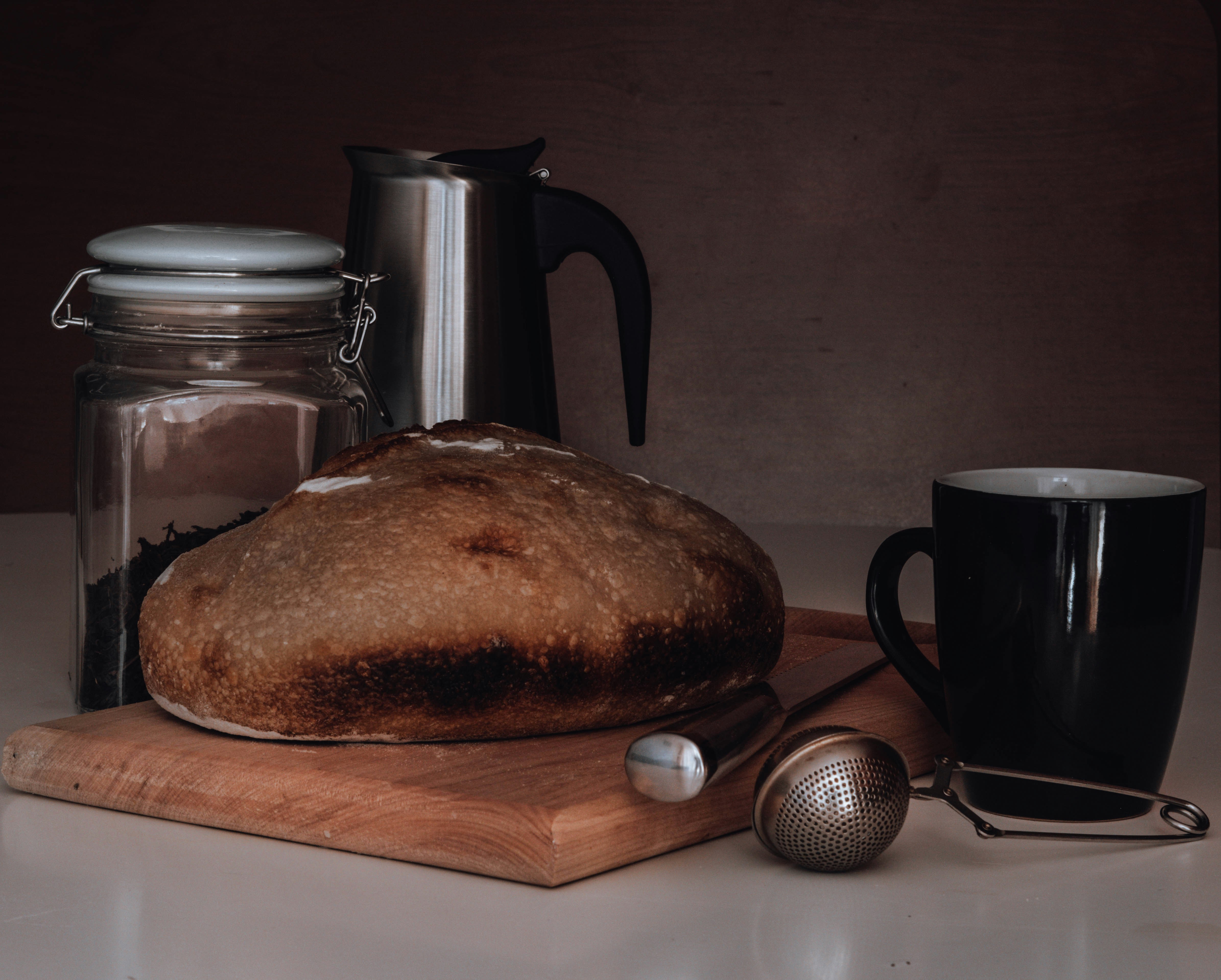 Crust on Wood: A Quiet Morning Still Life with Bread, Jar, and Mug