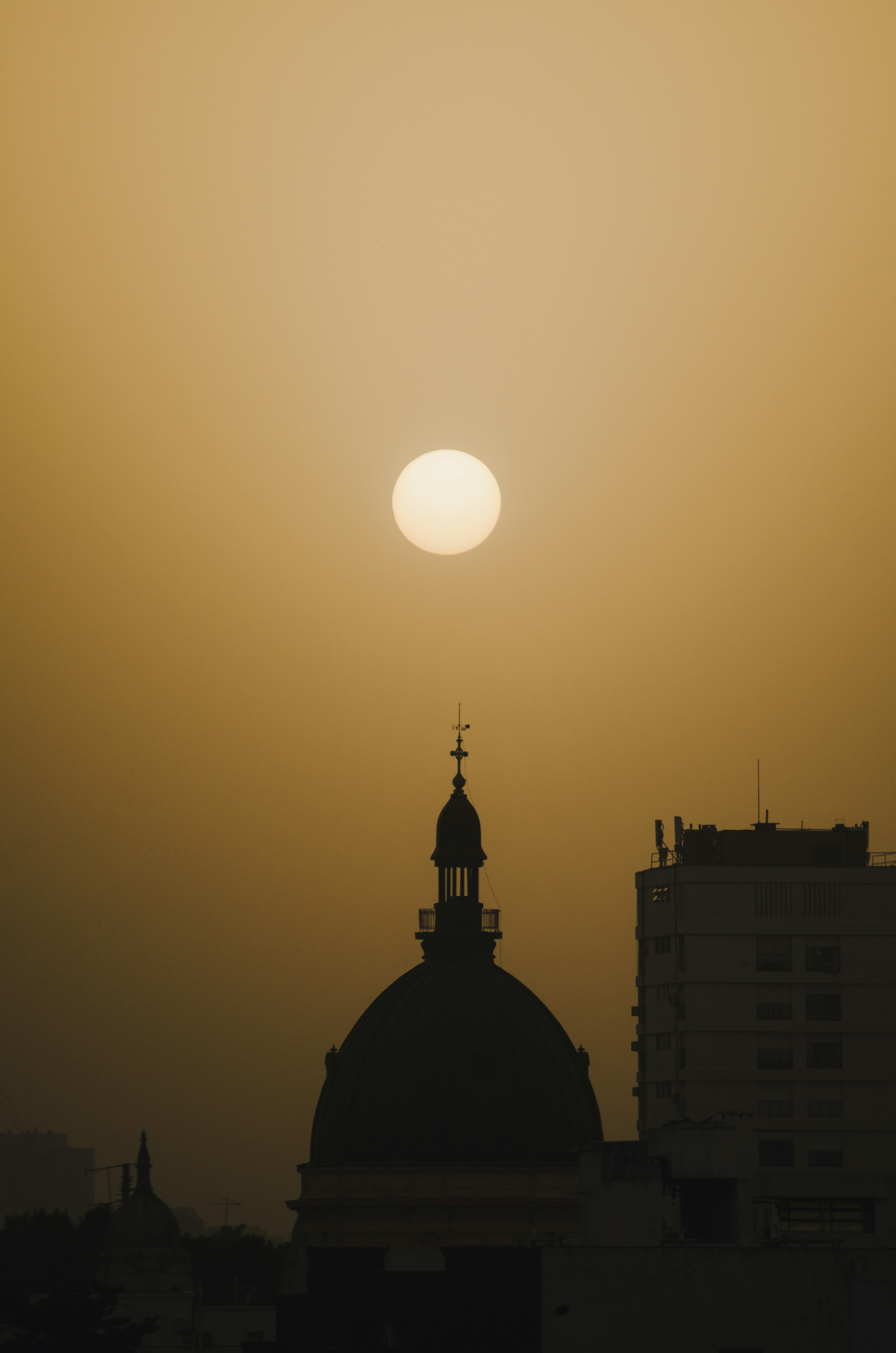 The sun is setting over a building with a dome photo – Free Building ...