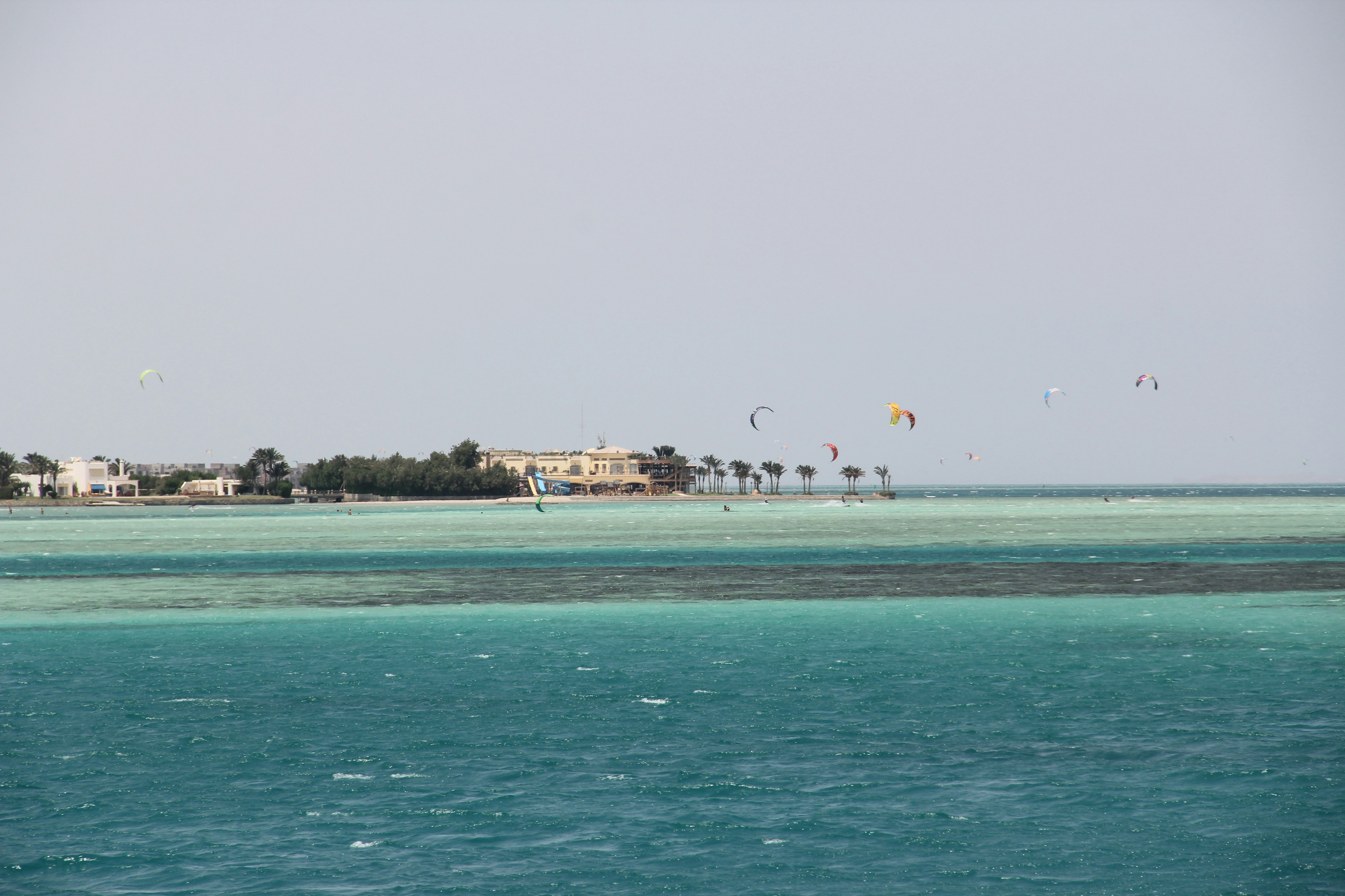 Turquoise Lagoon Kite Parade Along a Quiet Coastal Horizon
