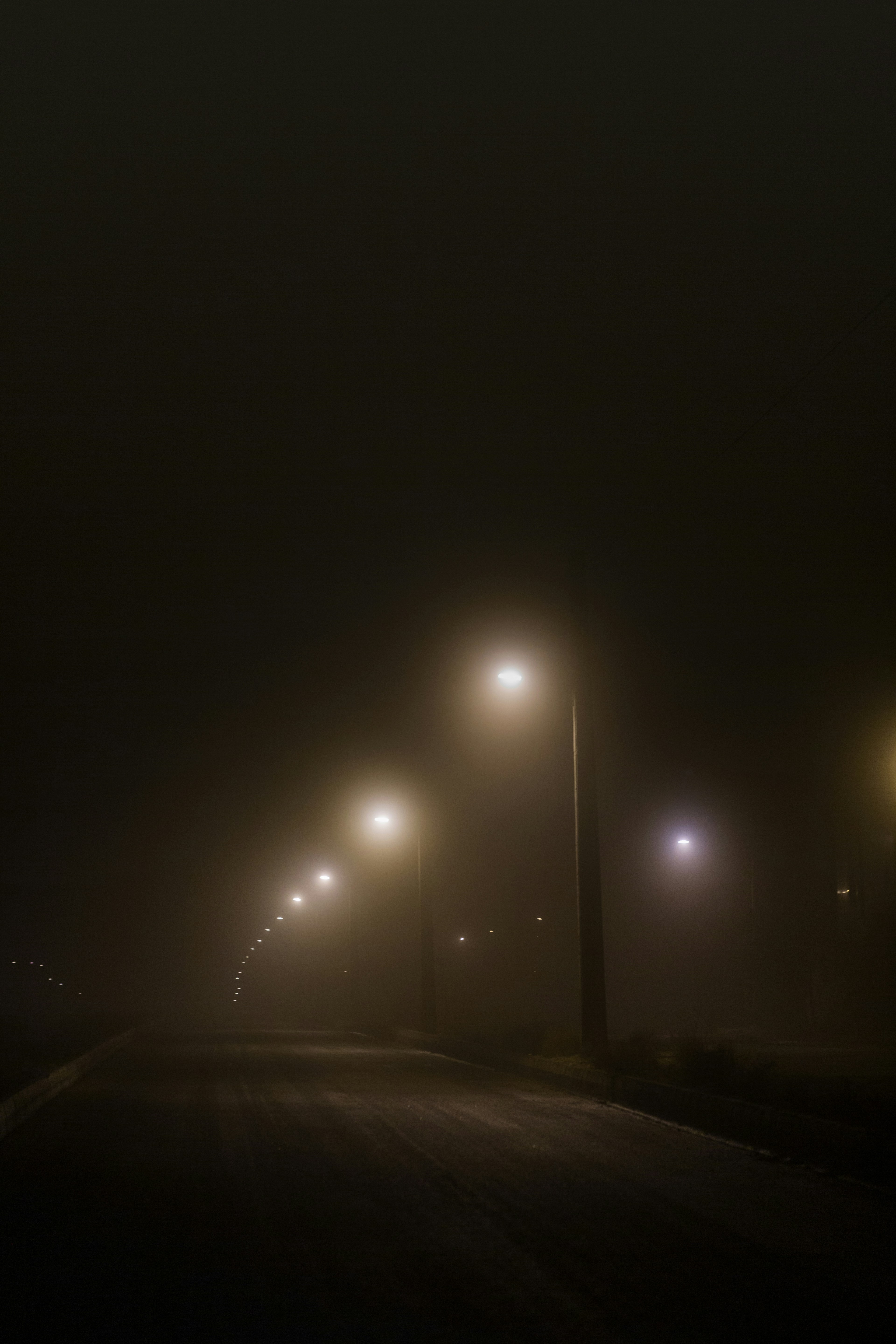 A foggy street with street lights on a foggy night photo – Free Light ...