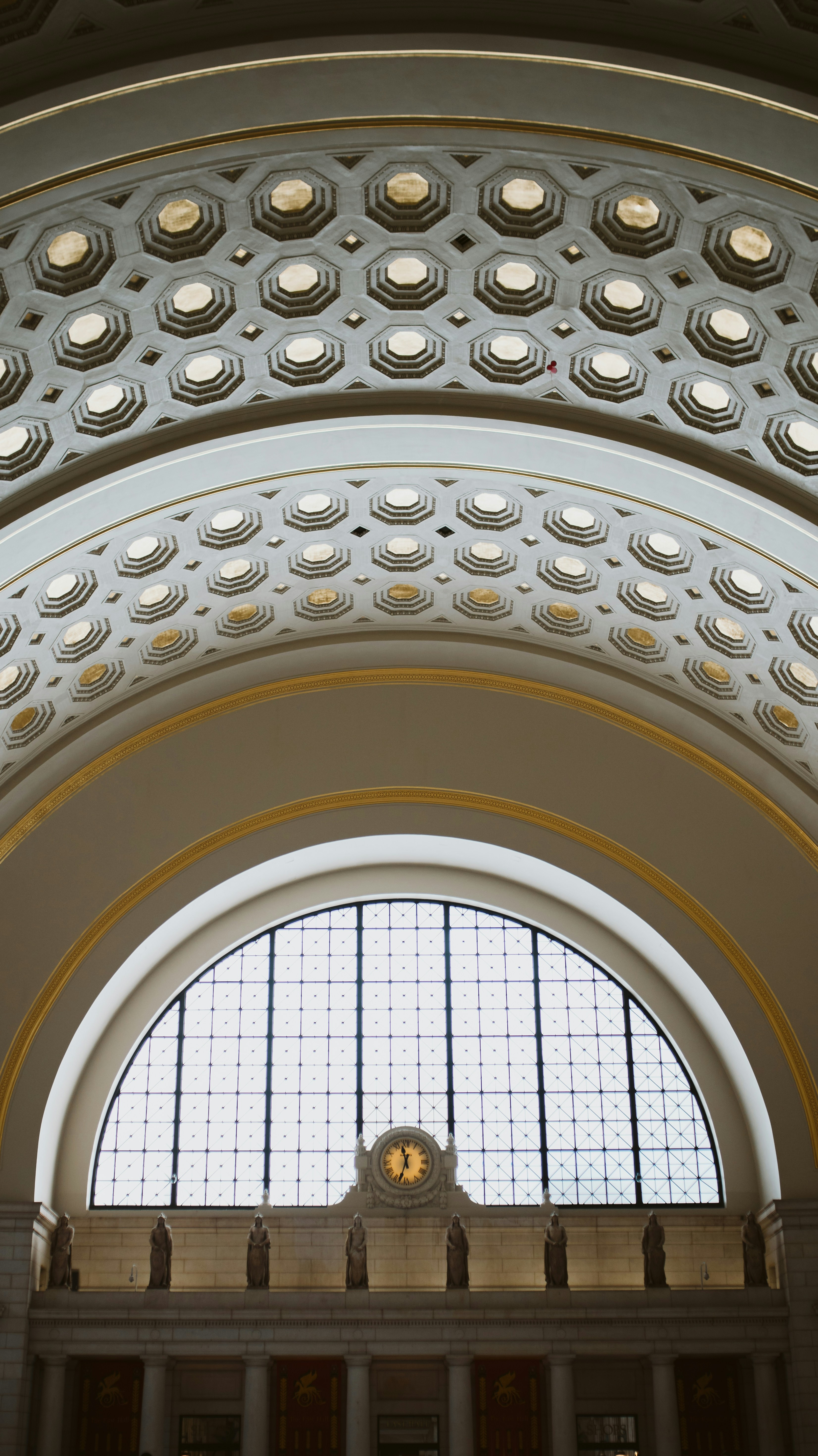 the ceiling of a large building with a clock on it