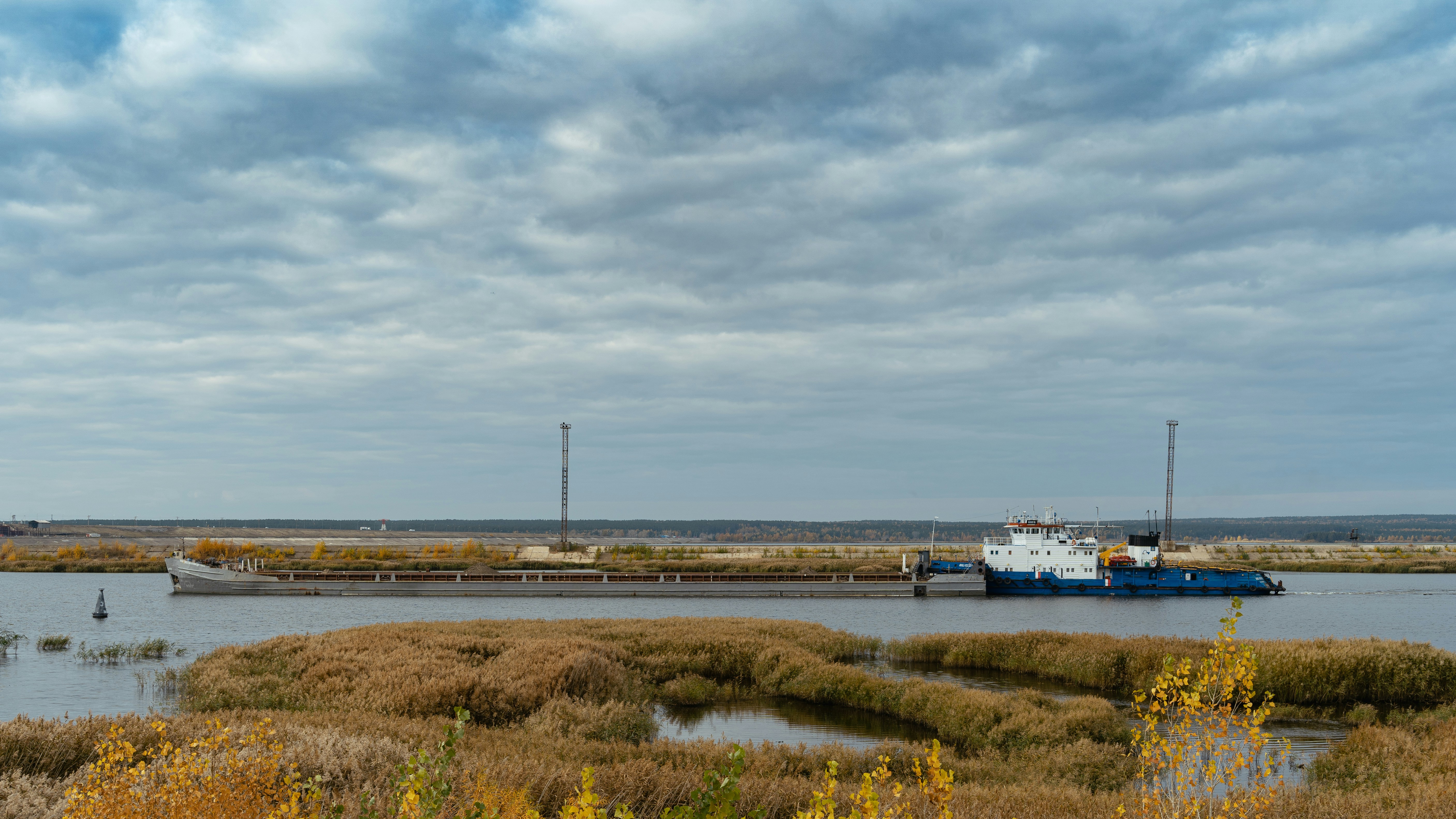 Blue Tug by the Salt Marsh Channel under Overcast Skies