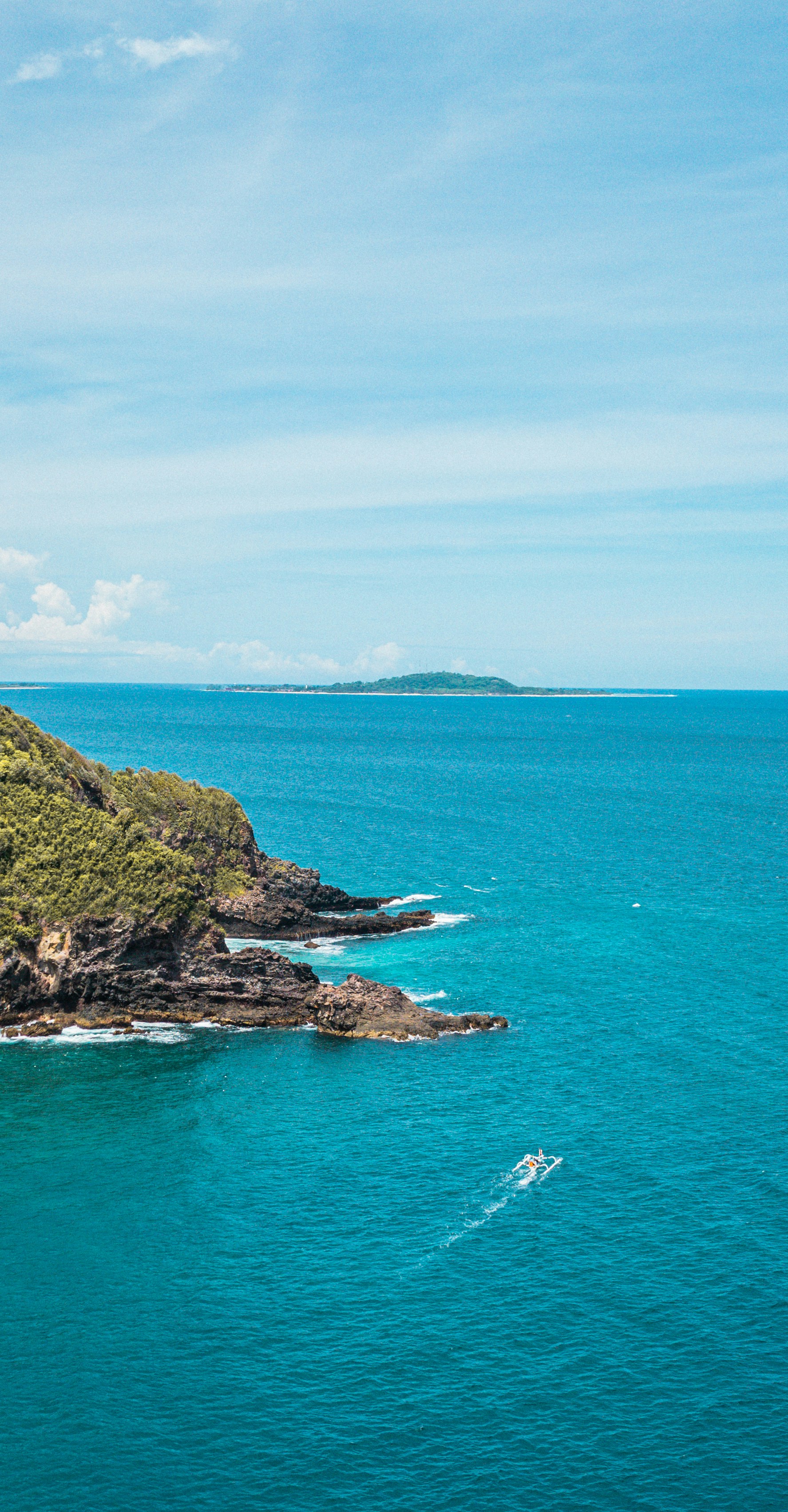 Turquoise Wake Along a Cliffside Blue