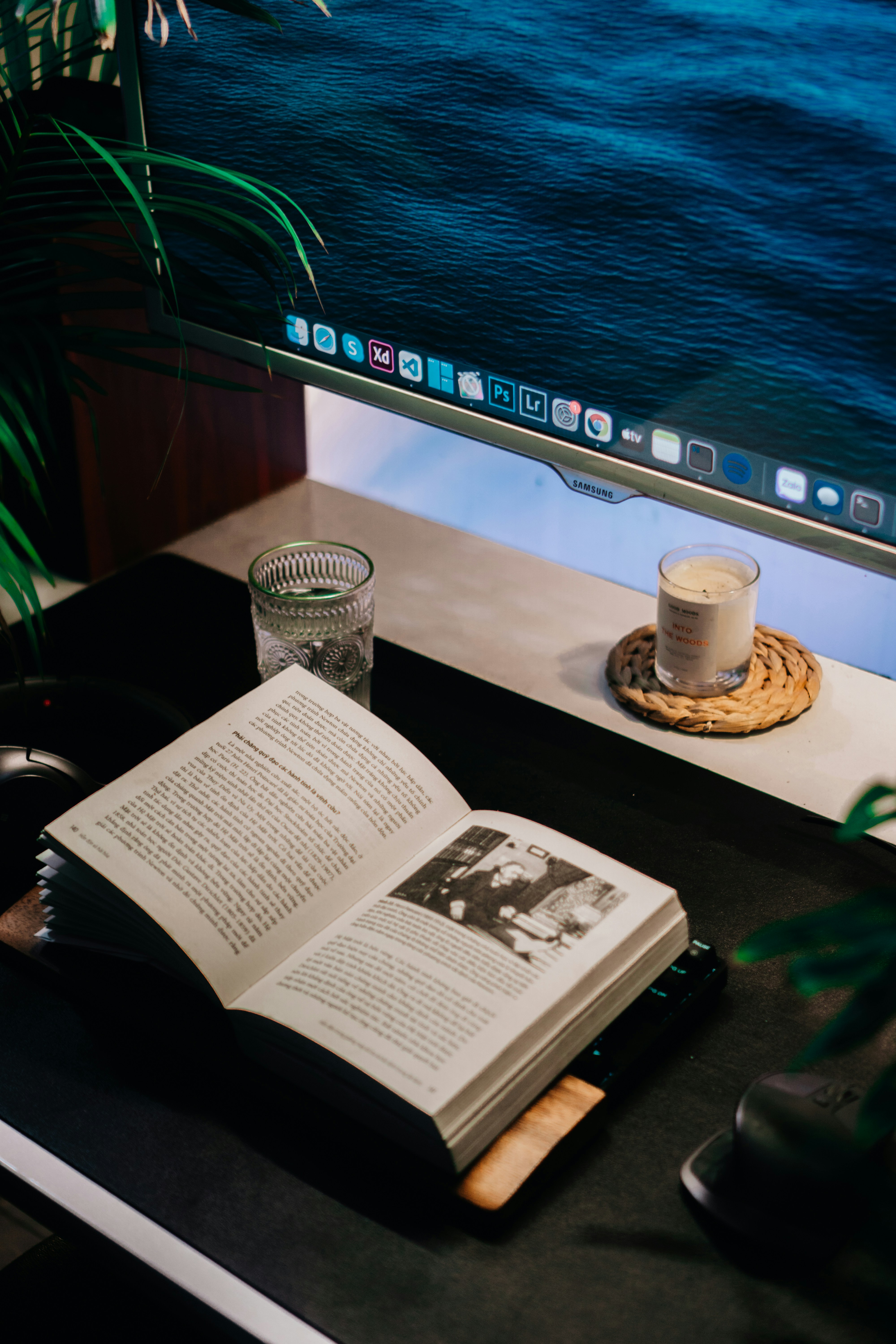 An open book sitting on top of a desk next to a computer monitor photo ...