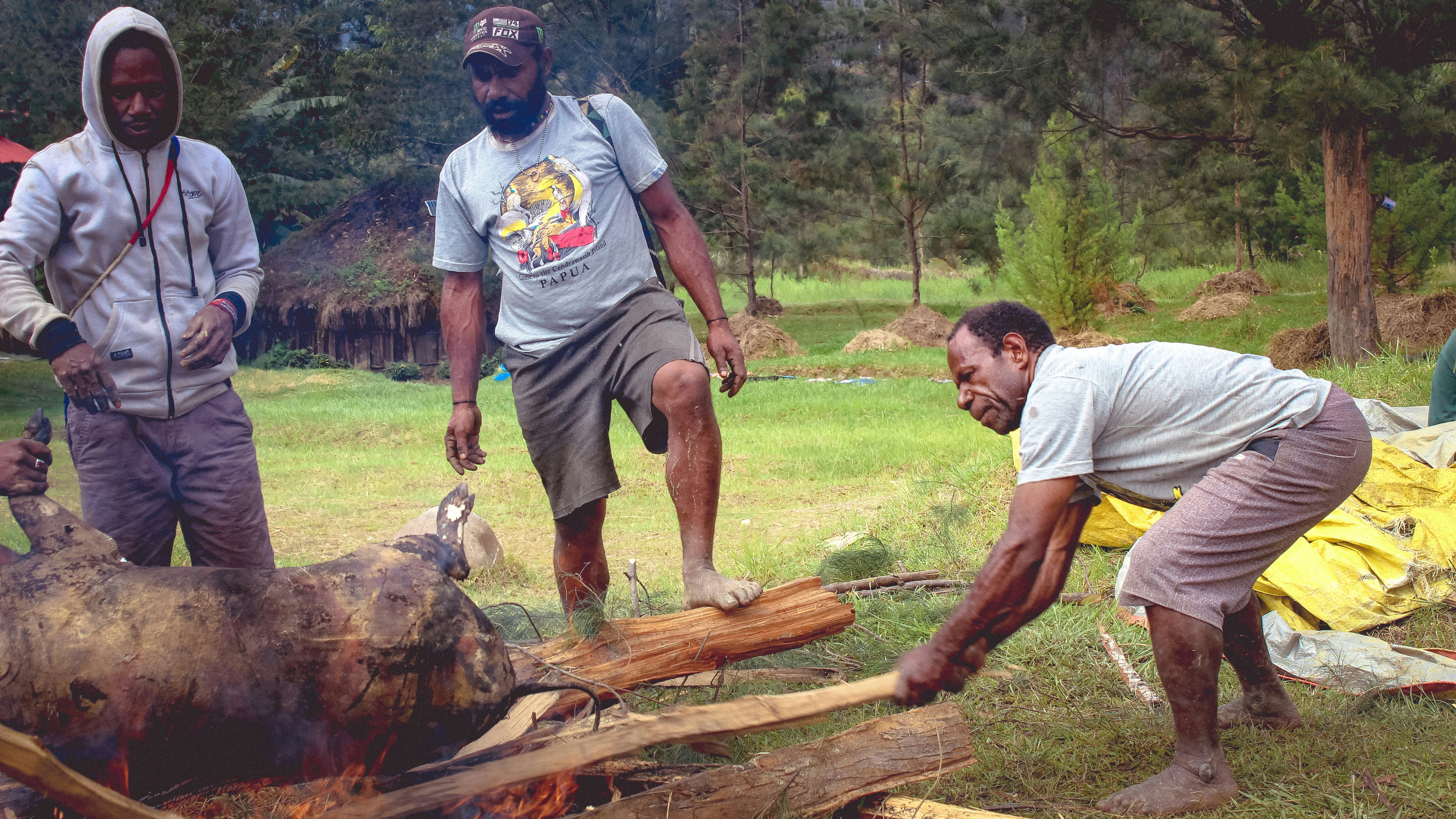 a group of men standing around a fire pit