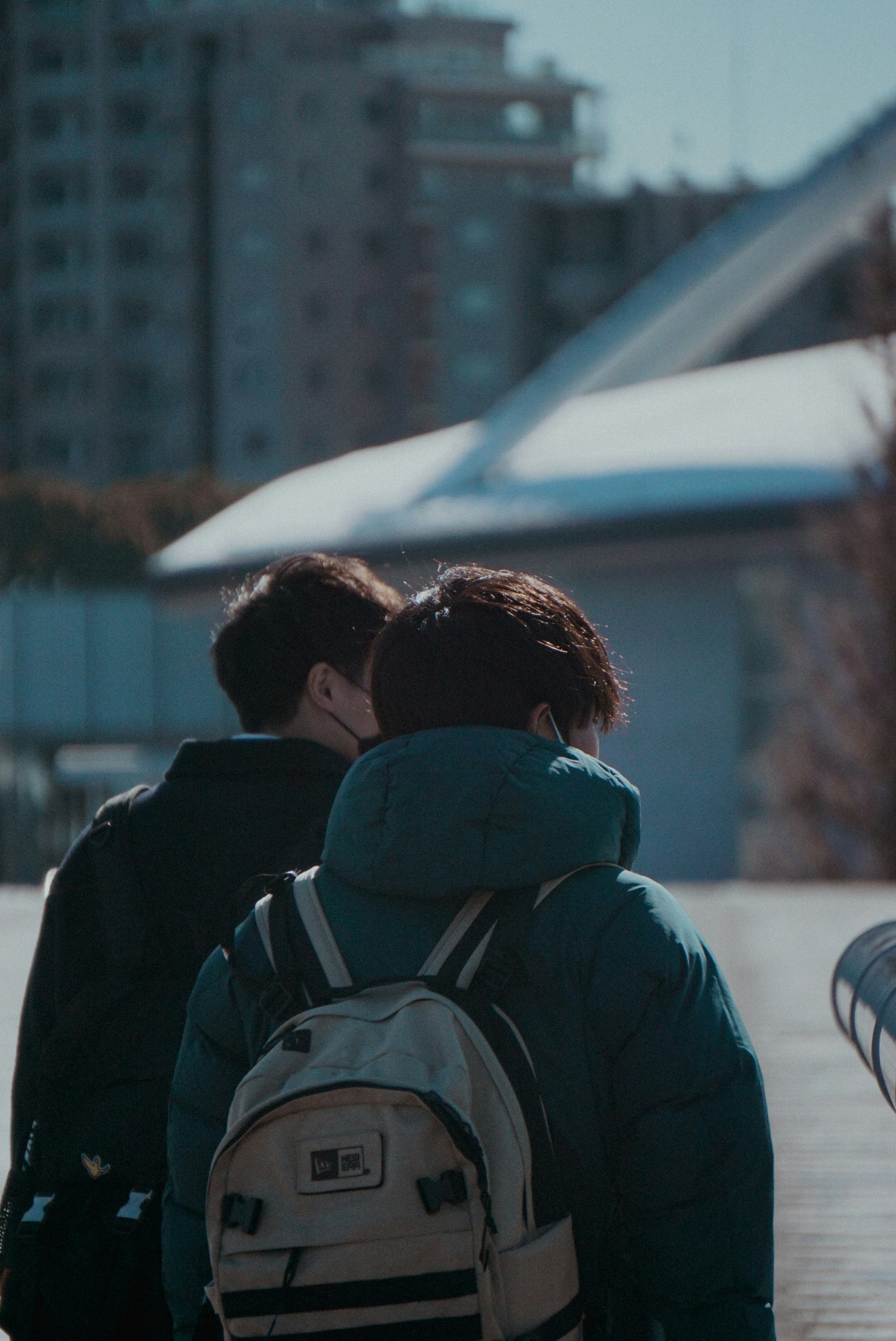 Two boys are sitting on a bench with their backs to each other photo ...