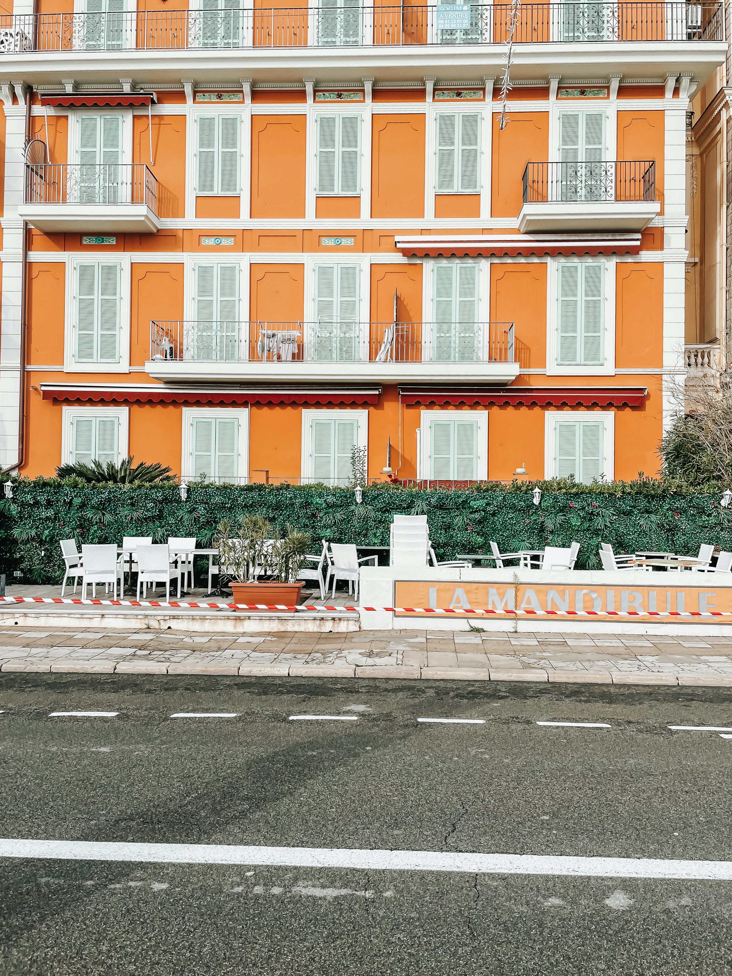 an orange building with white chairs in front of it